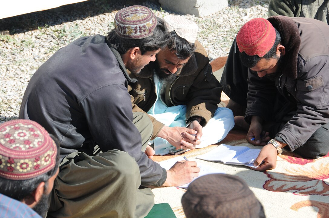 Afghan men teach each other English and math during a training session ...