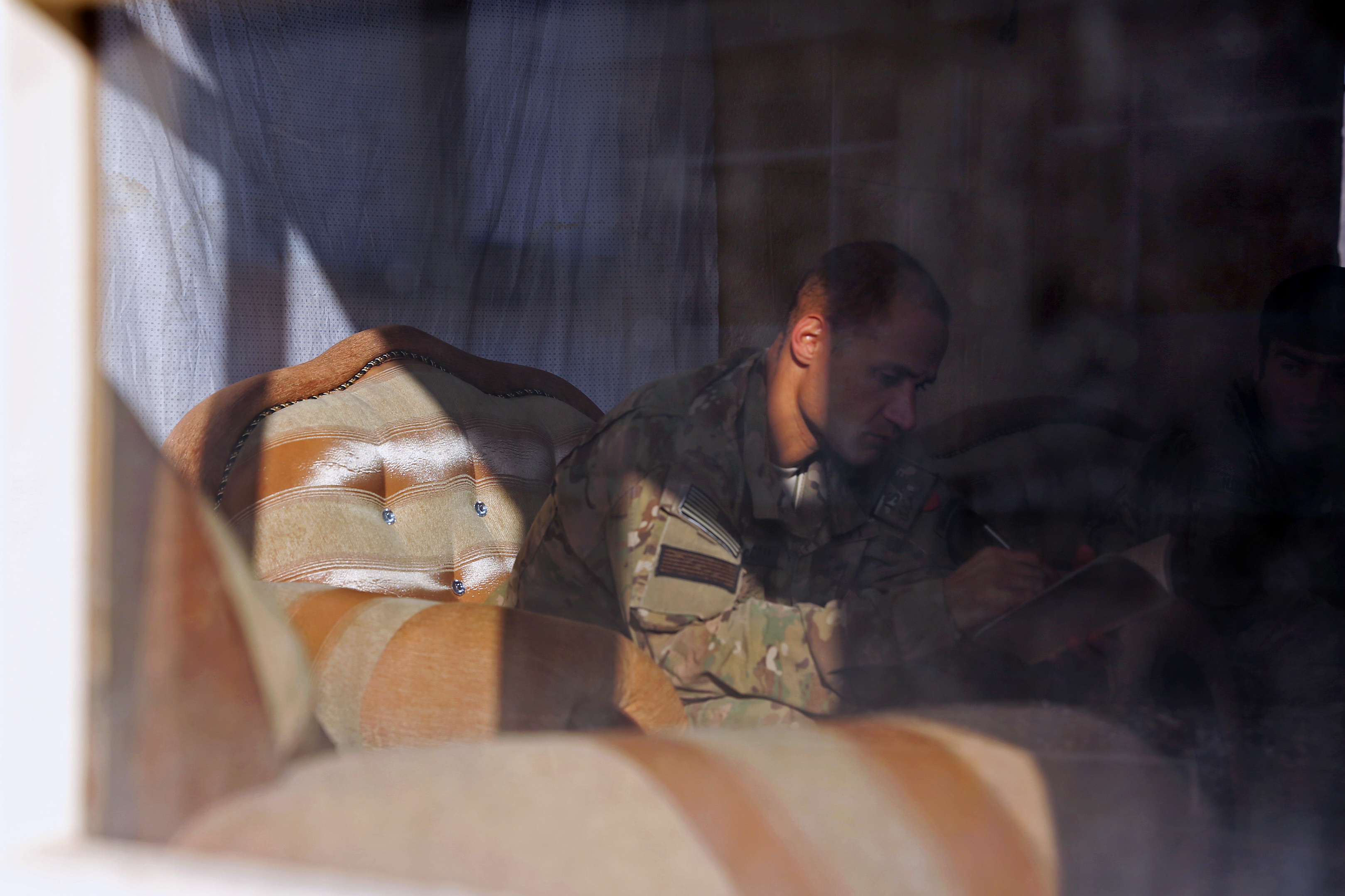 U.S. Navy Cmdr. Louis McCray takes notes while meeting with Farah ...