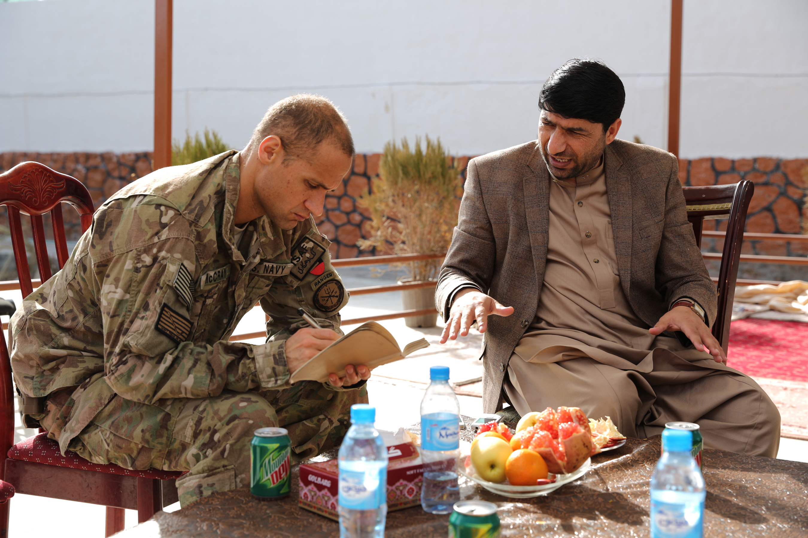 U.S. Navy Cmdr. Louis McCray, left, takes notes during a meeting with ...