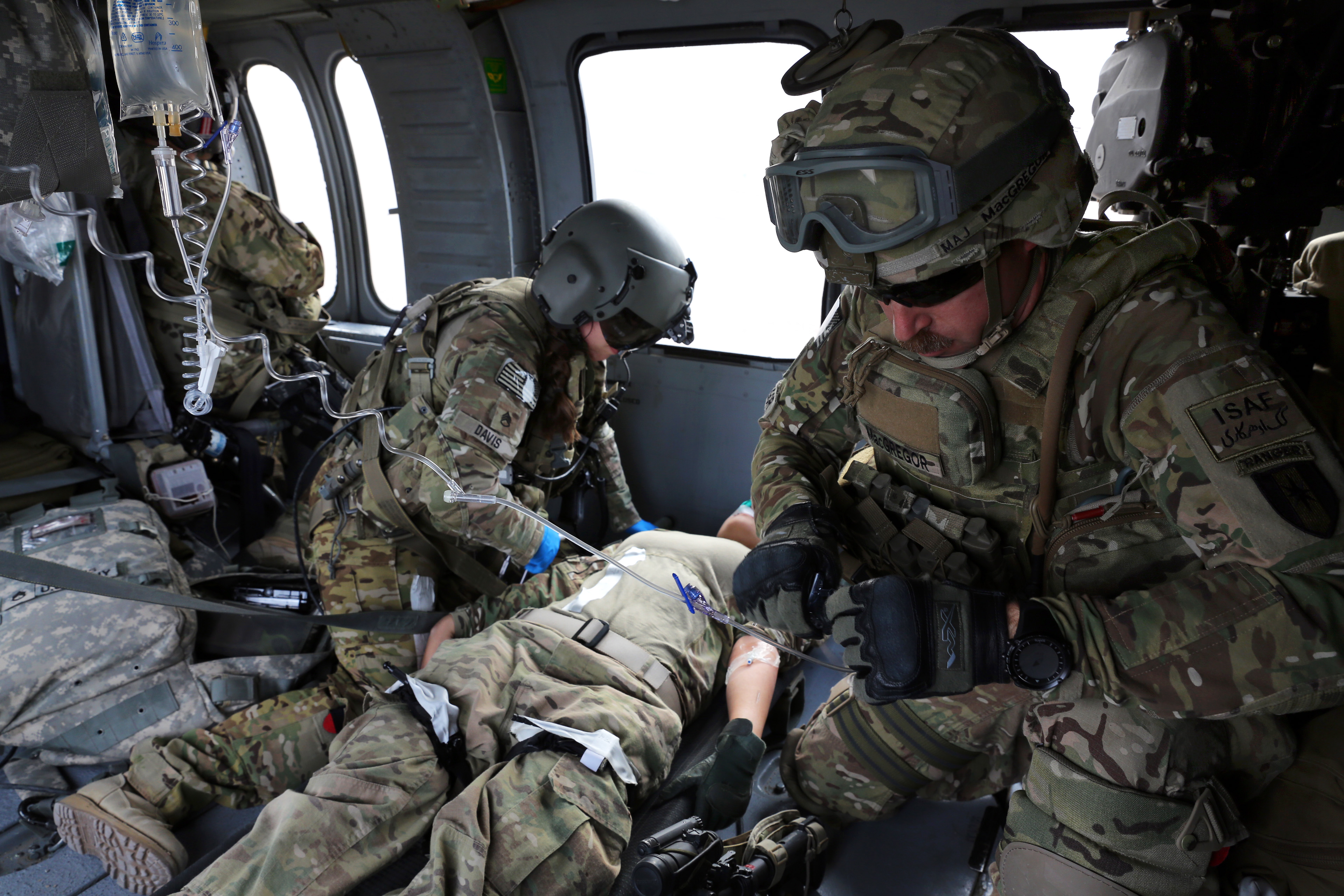U.S. Army Maj. Jacob MacGregor, right, prepares an IV bag while U.S ...
