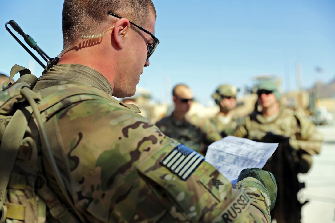U.S. Army Sgt. William Russell, front, conducts a mission brief before ...
