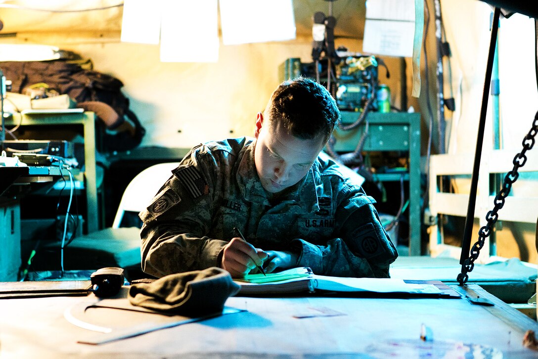 Army 1st Lt. Corey Miller takes notes from the day's M119A2 105mm ...