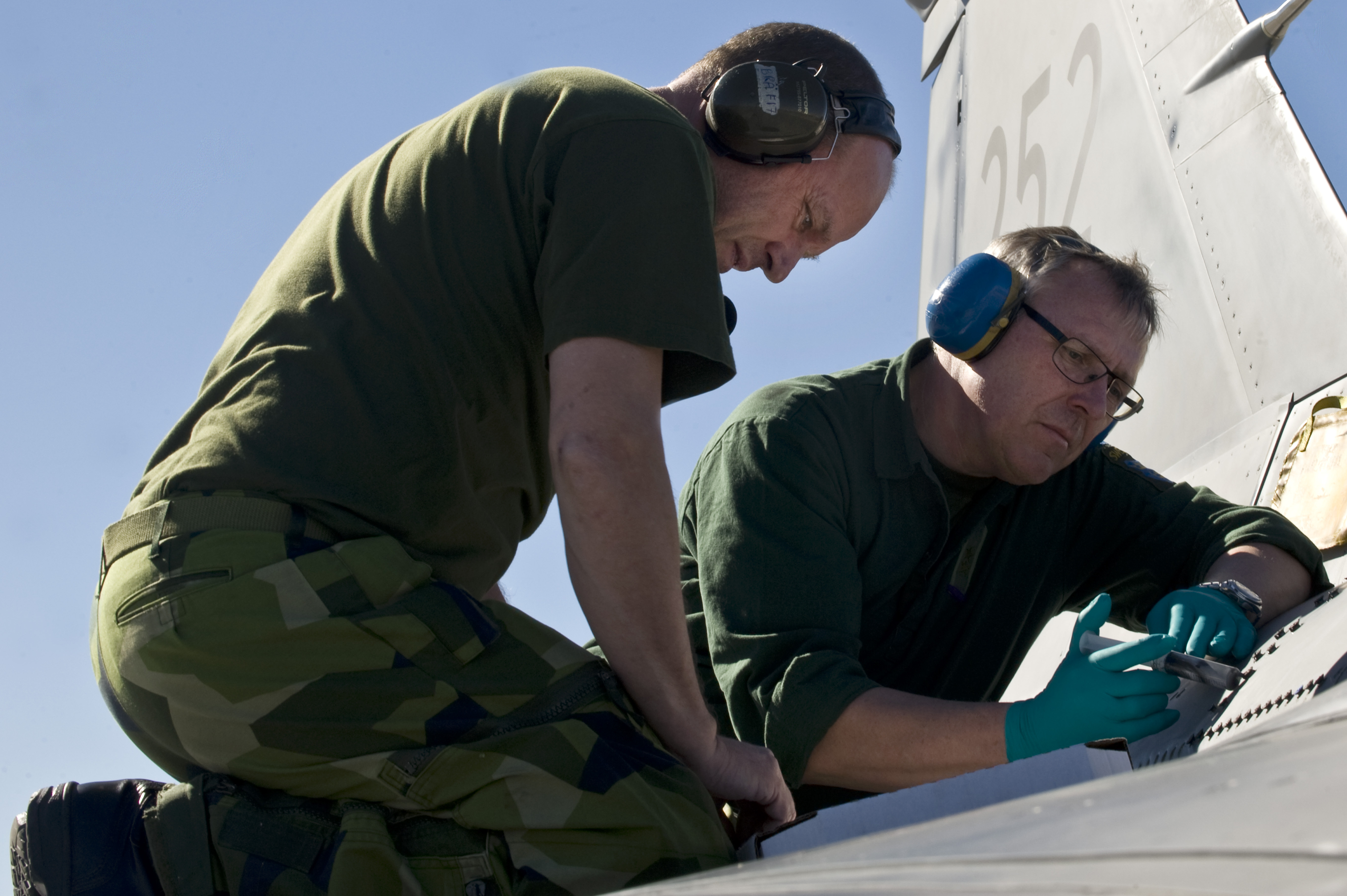 Swedish technicians attach a panel to a JAS-39 Gripen during exercise ...