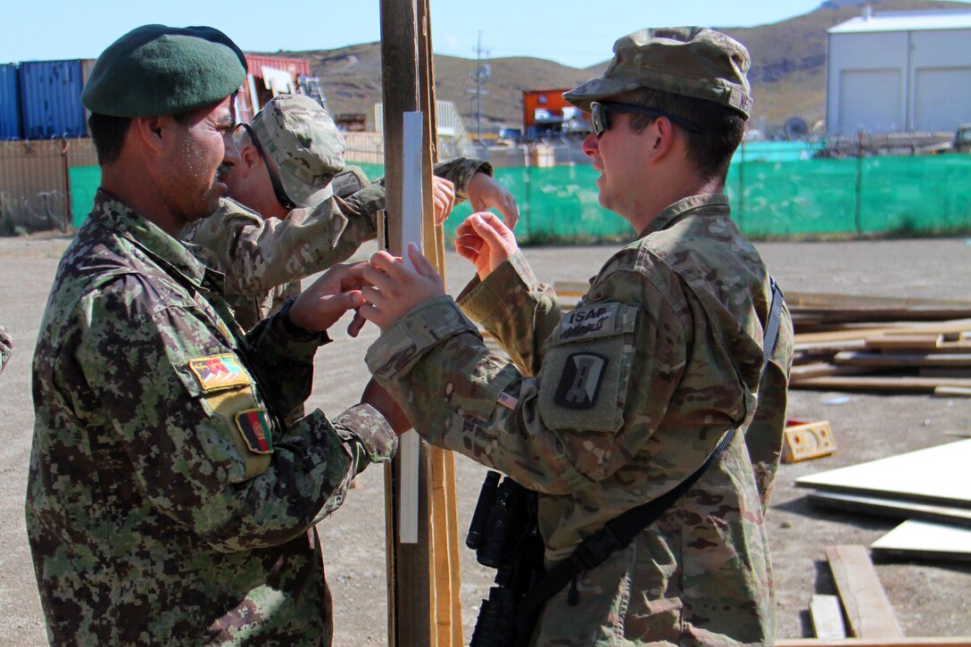 U.S. Army Spc. Taylor Neitman, right, observes as an Afghan soldier ...