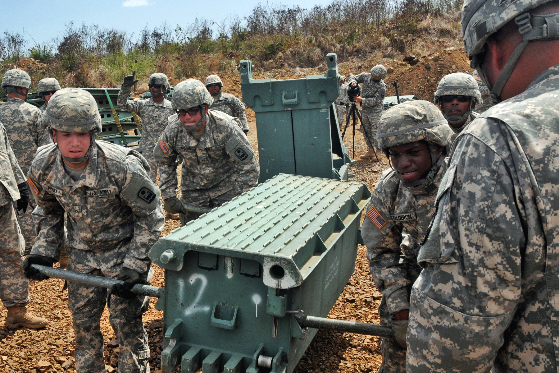 Soldiers move a supporting beam while learning to assemble a medium ...