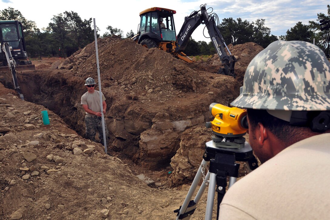 Air Force Tech. Sgt. Joshua Smith, left, holds a leveling rod as Air ...