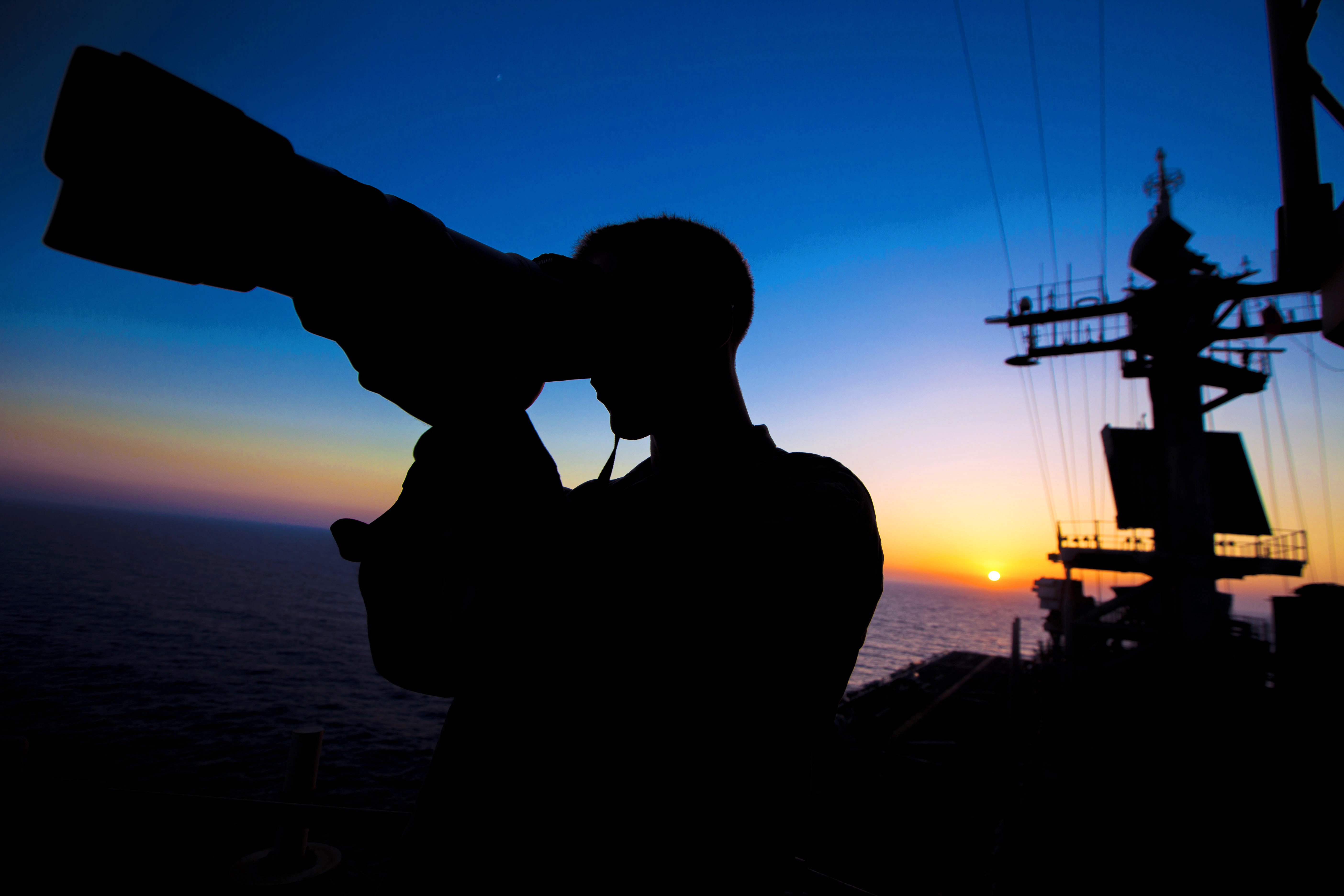 U.S. Marine Corps Cpl. Kyle Runnels takes photos at sunset aboard the ...
