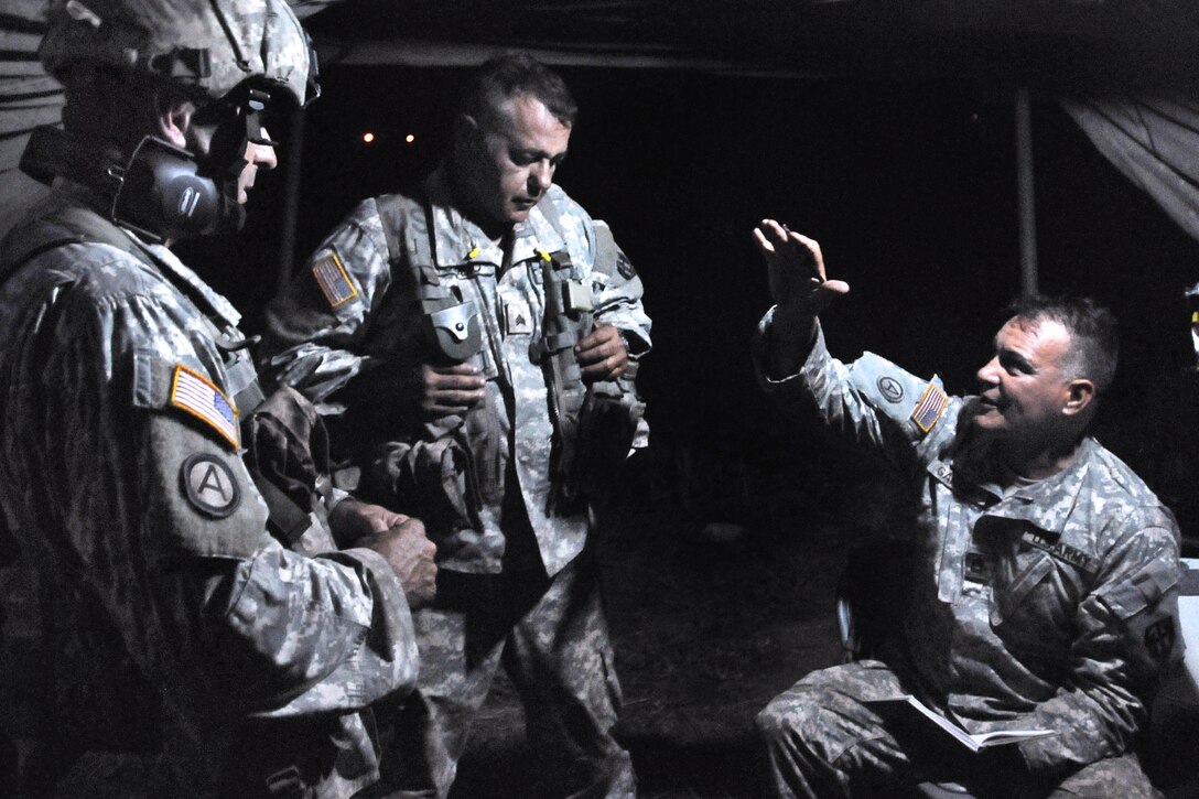 Army Sgt. 1st. Class Danny Garcia, right, talks with his squad leaders ...