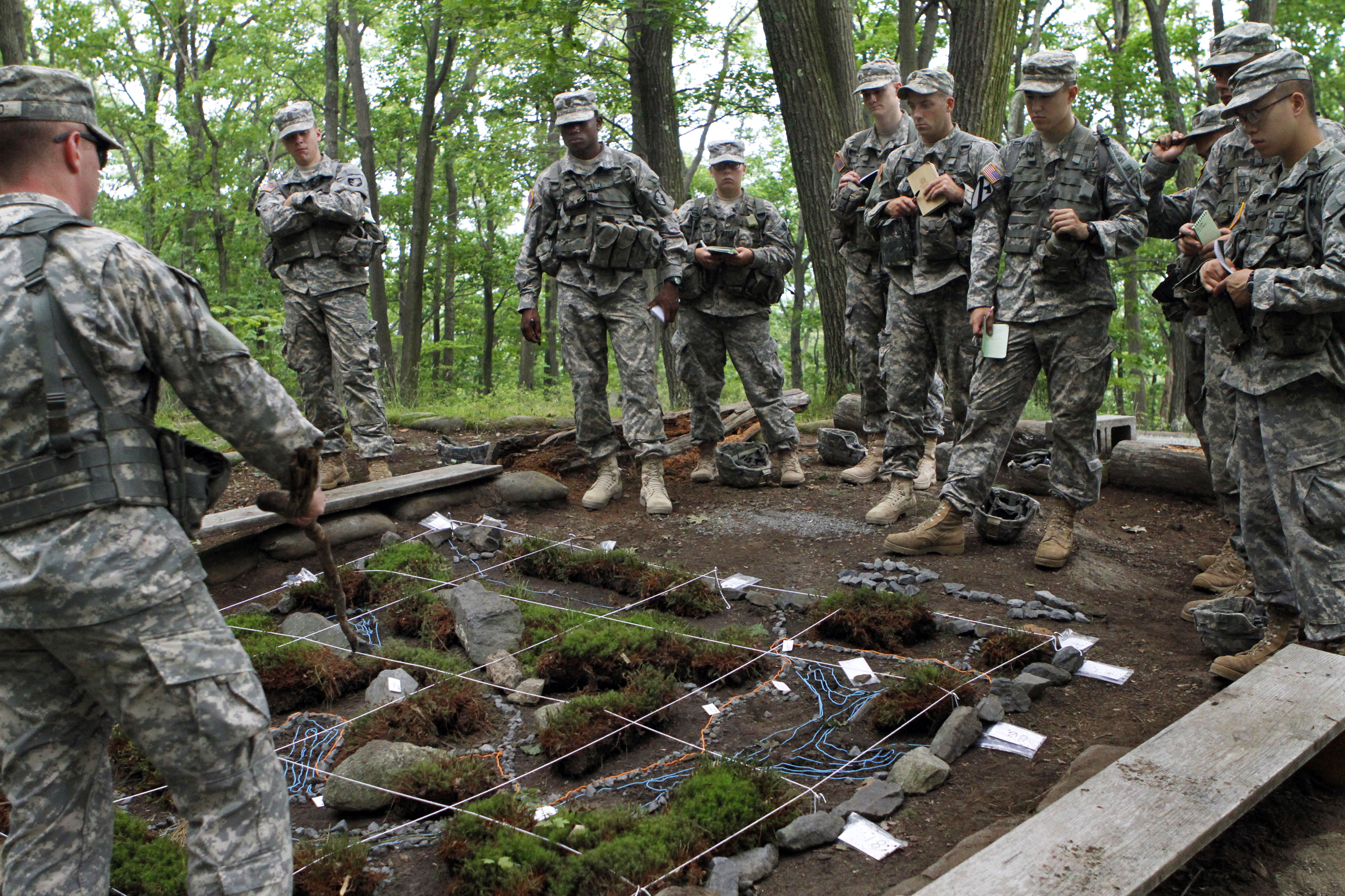 Army cadets receive a terrain map briefing by a soldier assigned to the ...
