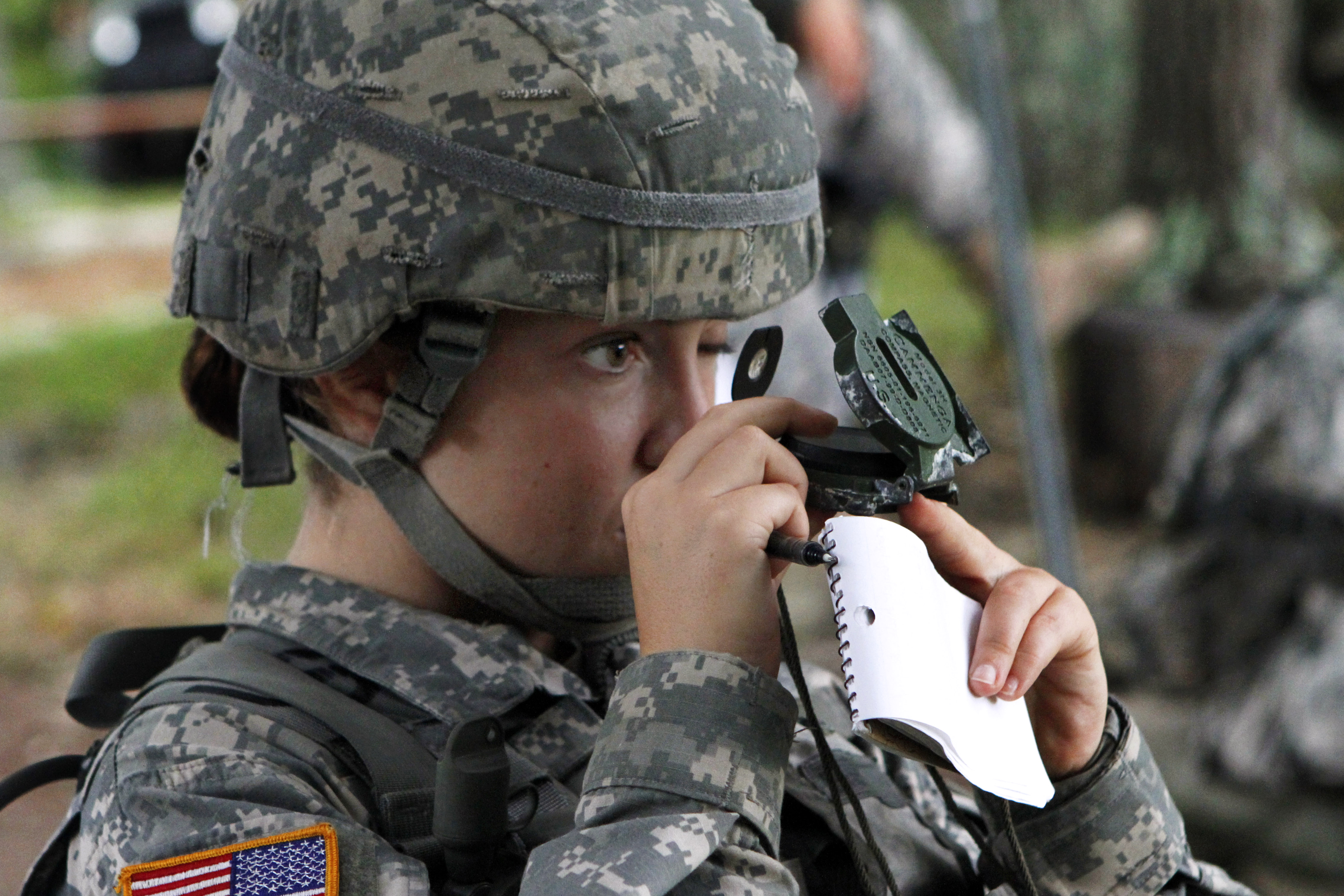 An Army cadet uses a lensatic compass during a field training exercise ...