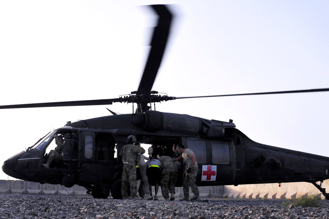 U.S. soldiers load a wounded Afghan Border policeman into a UH-60 Black ...