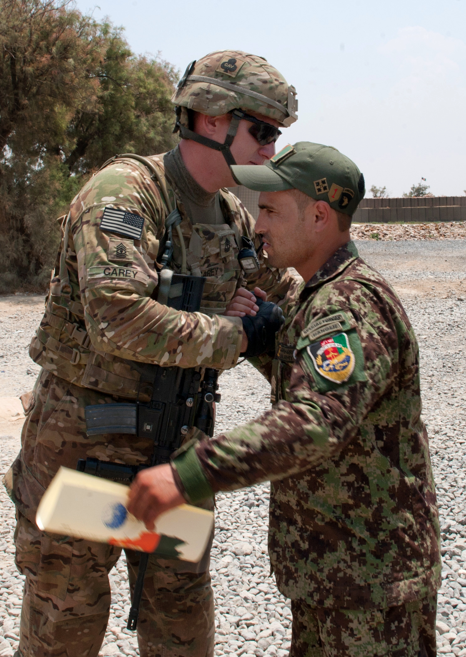 U.S. Army 1st Sgt. Christopher Carey, left, shakes hands and says ...
