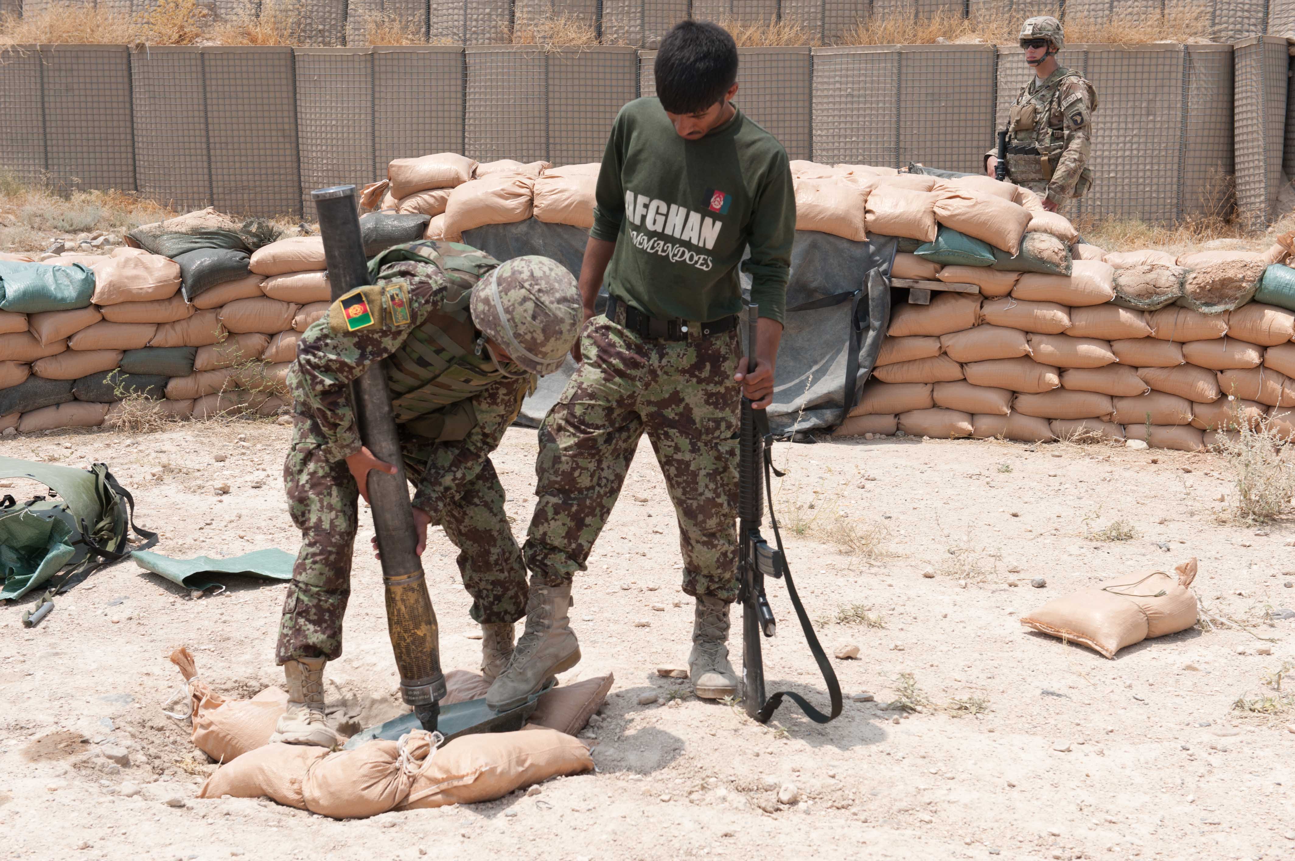 A U.S. soldier observes as Afghan National Army soldiers dismantle a ...