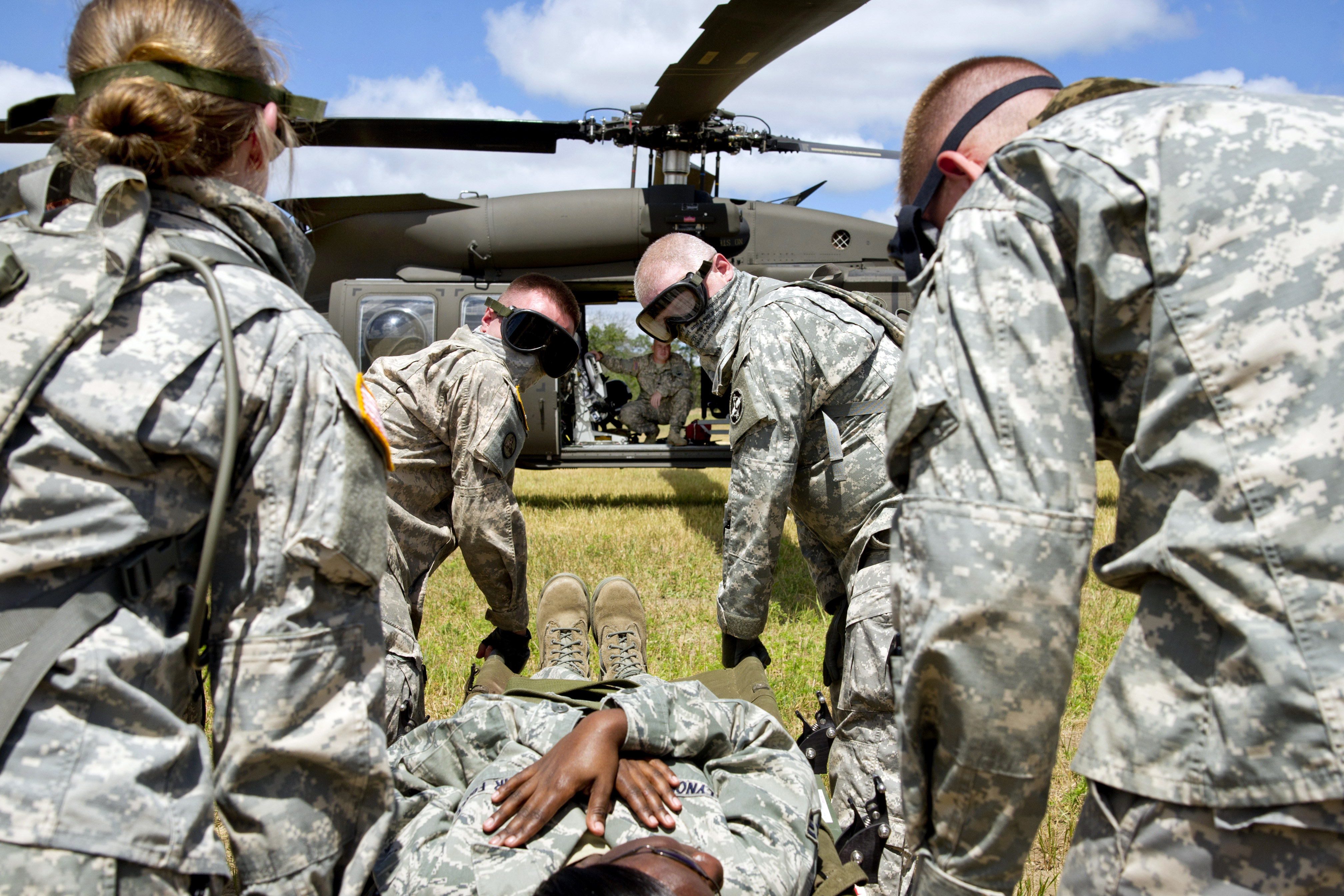 Soldiers and airmen prepare to load a simulated patient into a HH-60M ...
