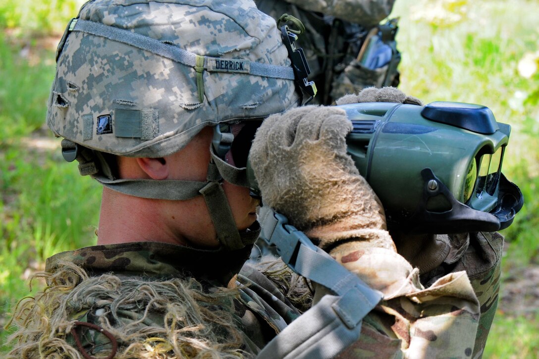 A paratrooper conducts a pre-combat inspection check of his equipment ...