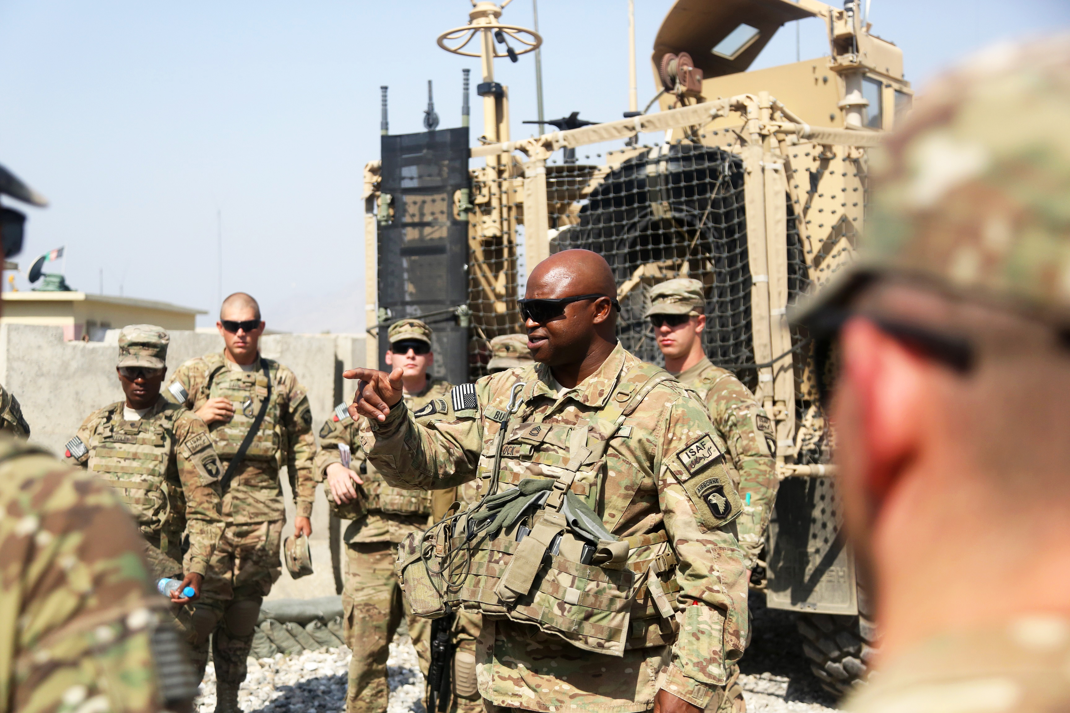 U.S. Army Sgt. 1st Class Troy Bullock, center, conducts a pre-mission ...