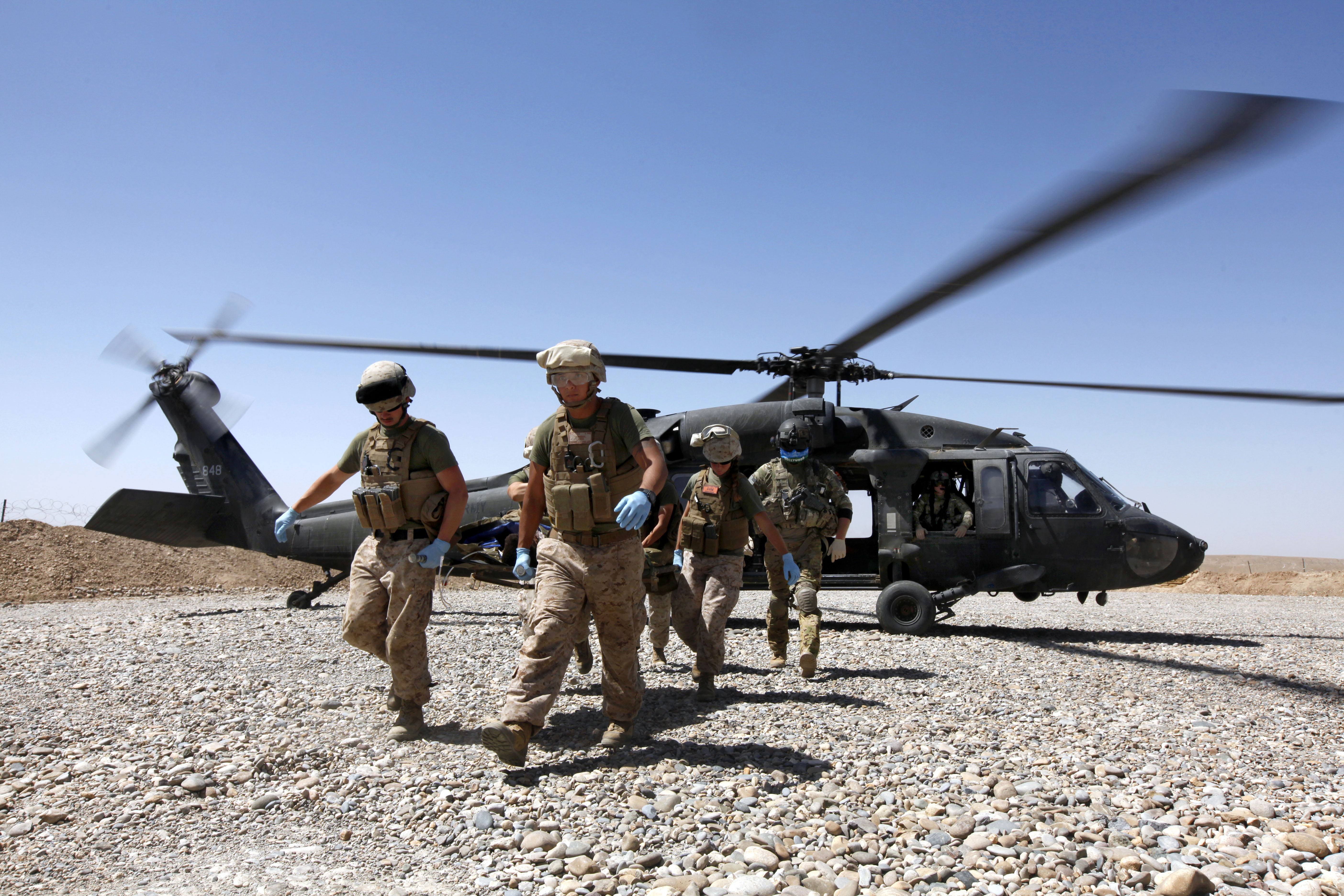U.S. Marines and sailors carry an injured Afghan soldier from a UH-60 ...