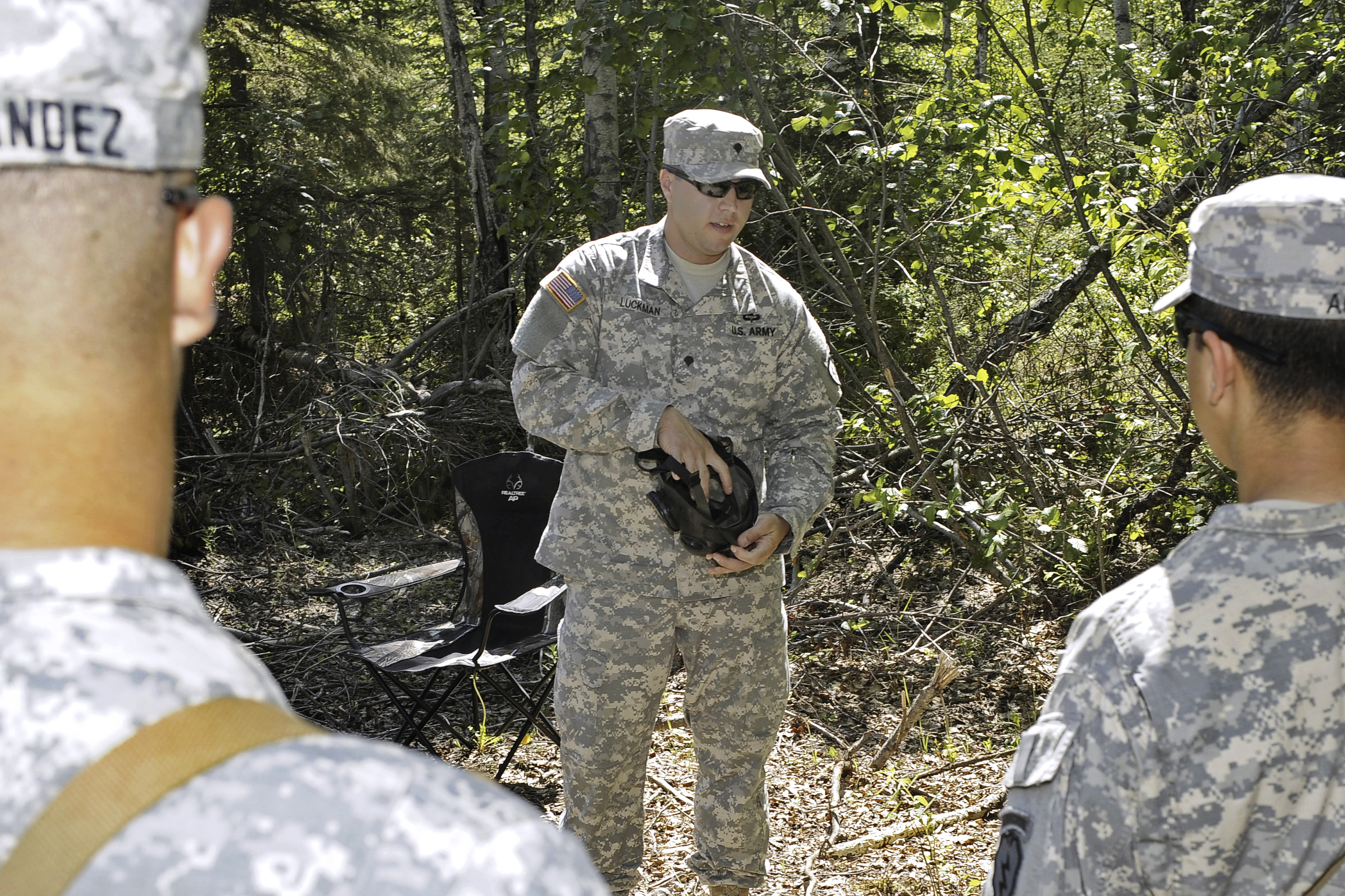 Army Spc. William Luckman, center, explains the features, care and ...