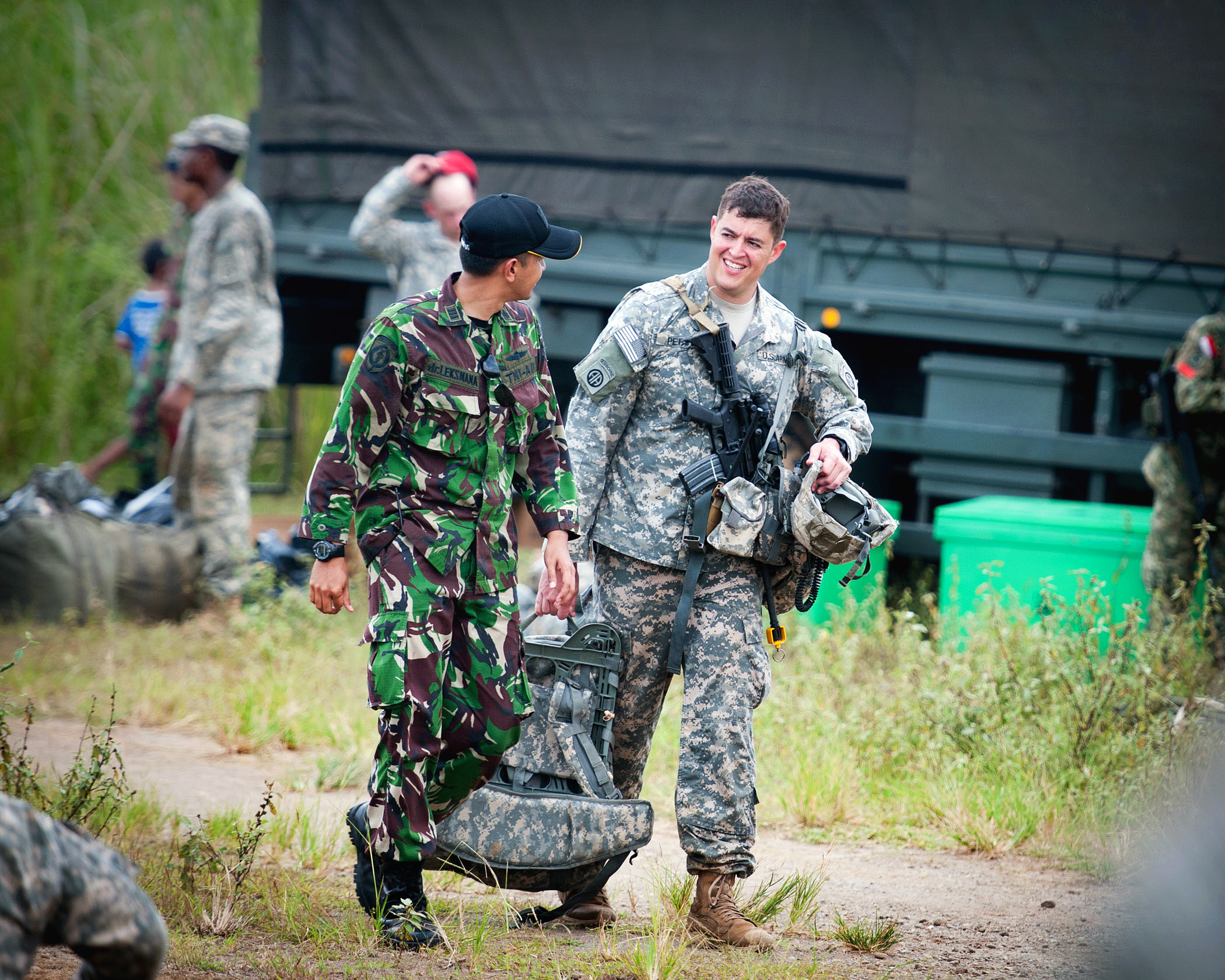 U.S. and Indonesian army paratroopers walk together after completing a ...