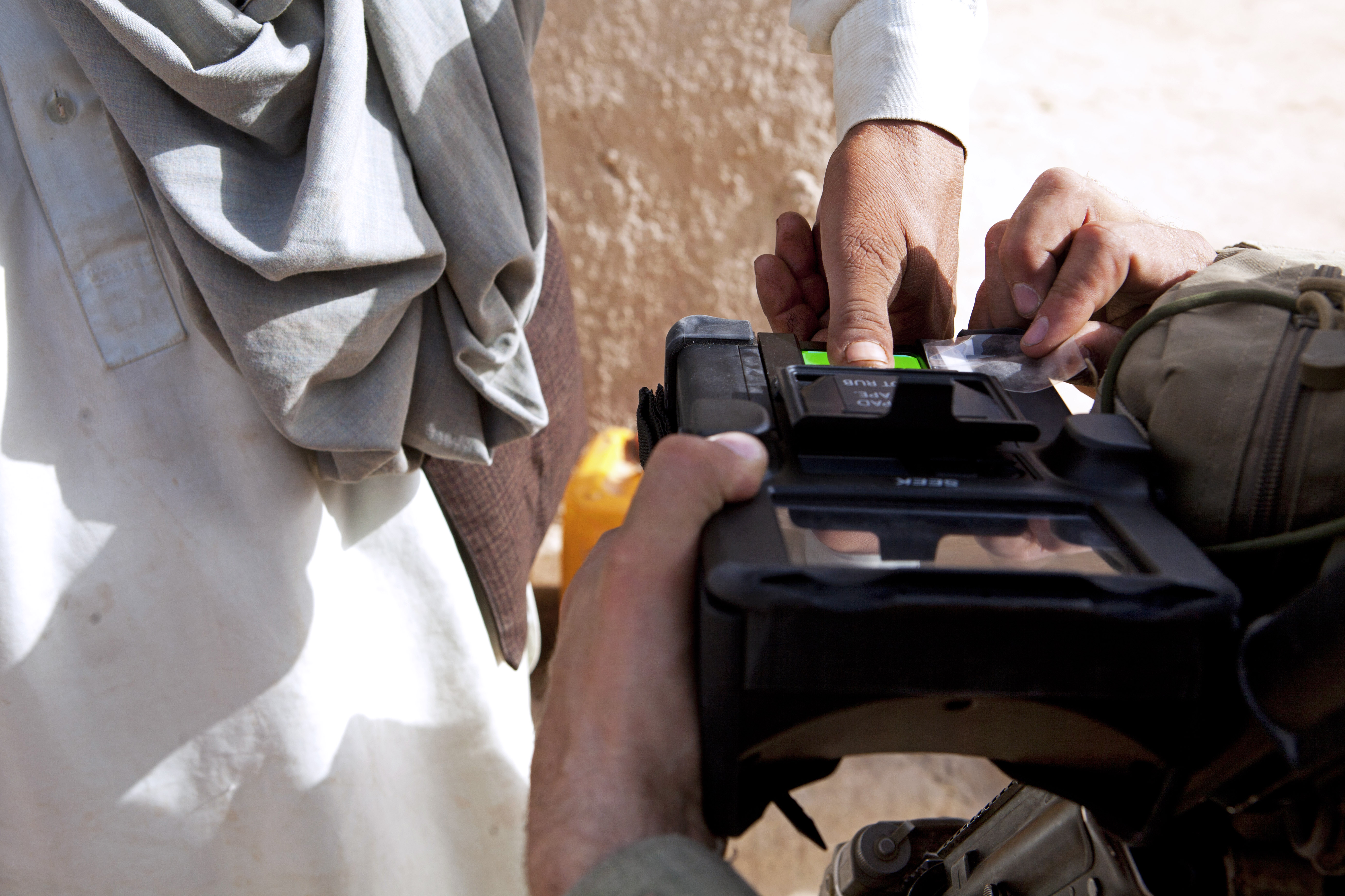 U.S. Army Staff Sgt. Michael Wilhoit records the fingerprints of an ...