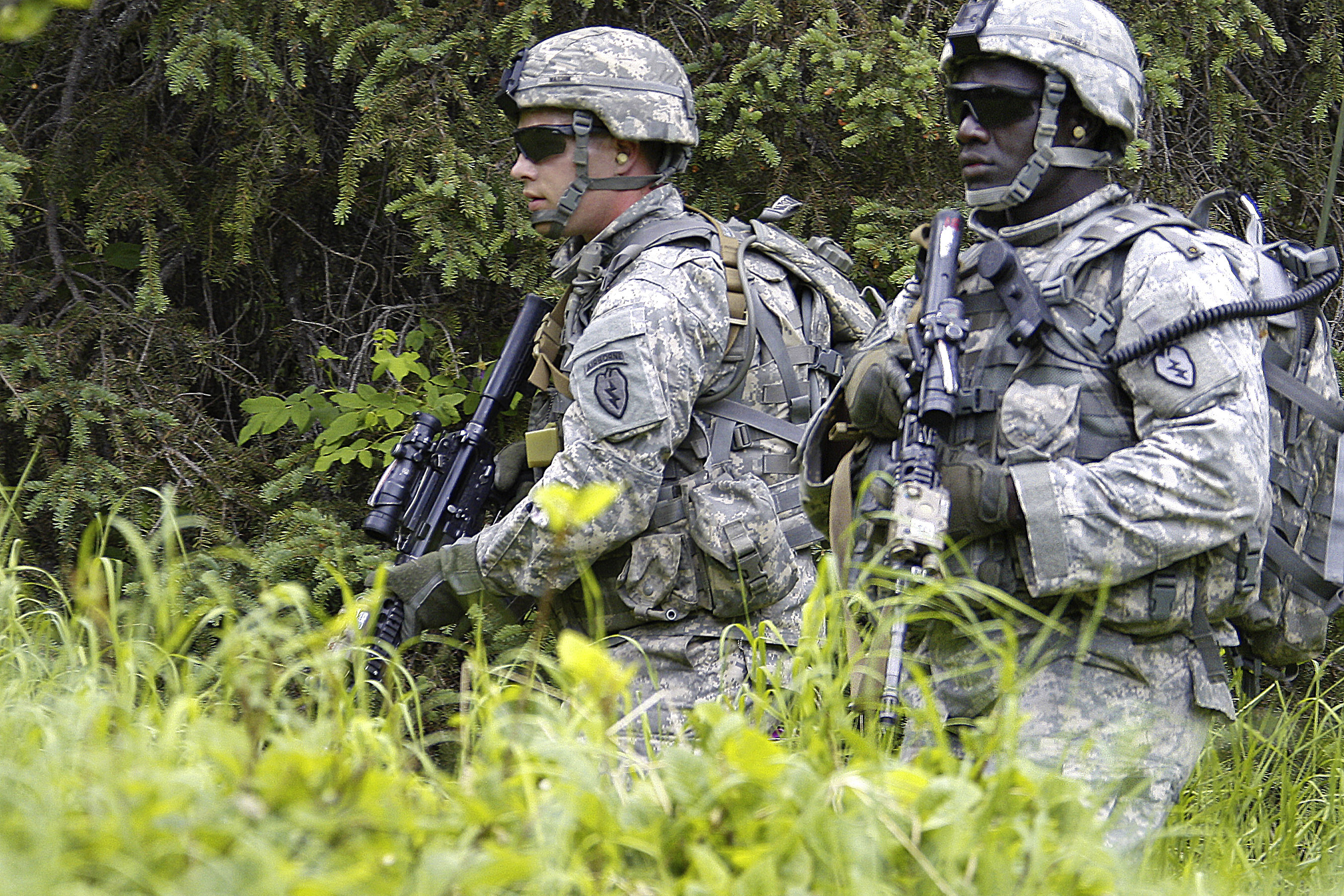 Army Pfc. Travis Watson, left, and Spc. Alfred Angelo move to their ...