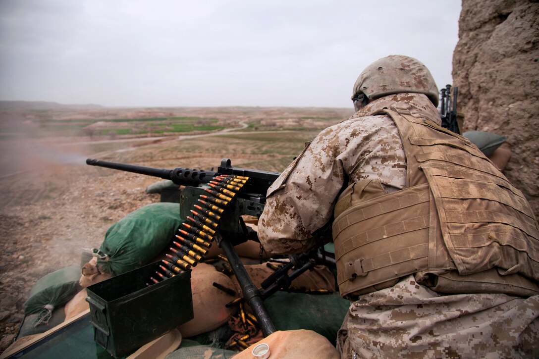 U.S. Marine Corps Lance Cpl. Kody King engages enemy positions with an M2HB .50-caliber machine ...