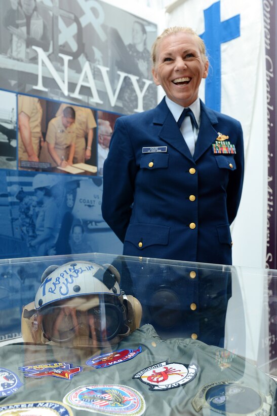 Navy Cmdr. Kim House, a chaplain, stands before her flight jacket on ...