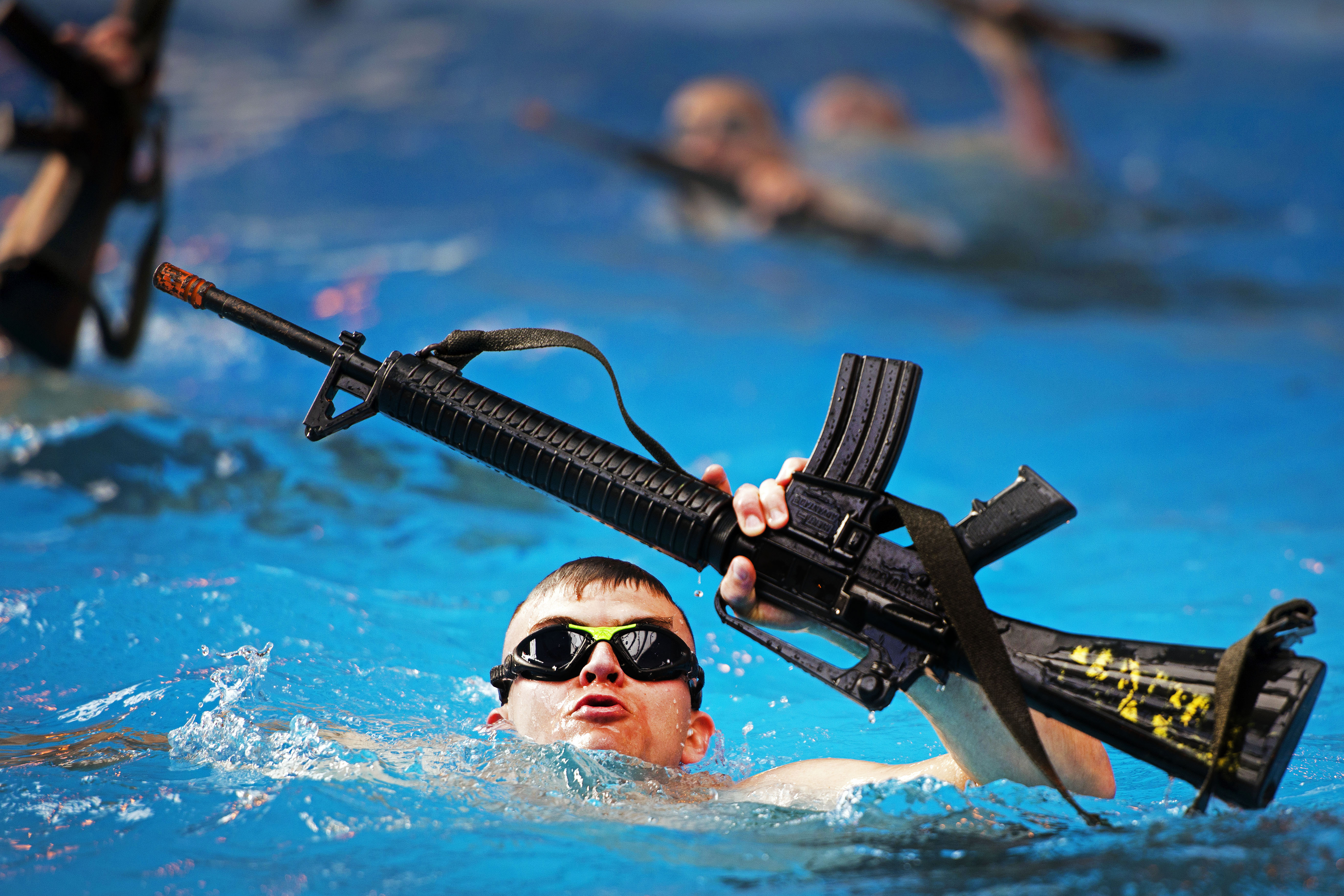 Marine Corps Cpl. Tanner Seitz performs a rifle swim as part of aquatic ...