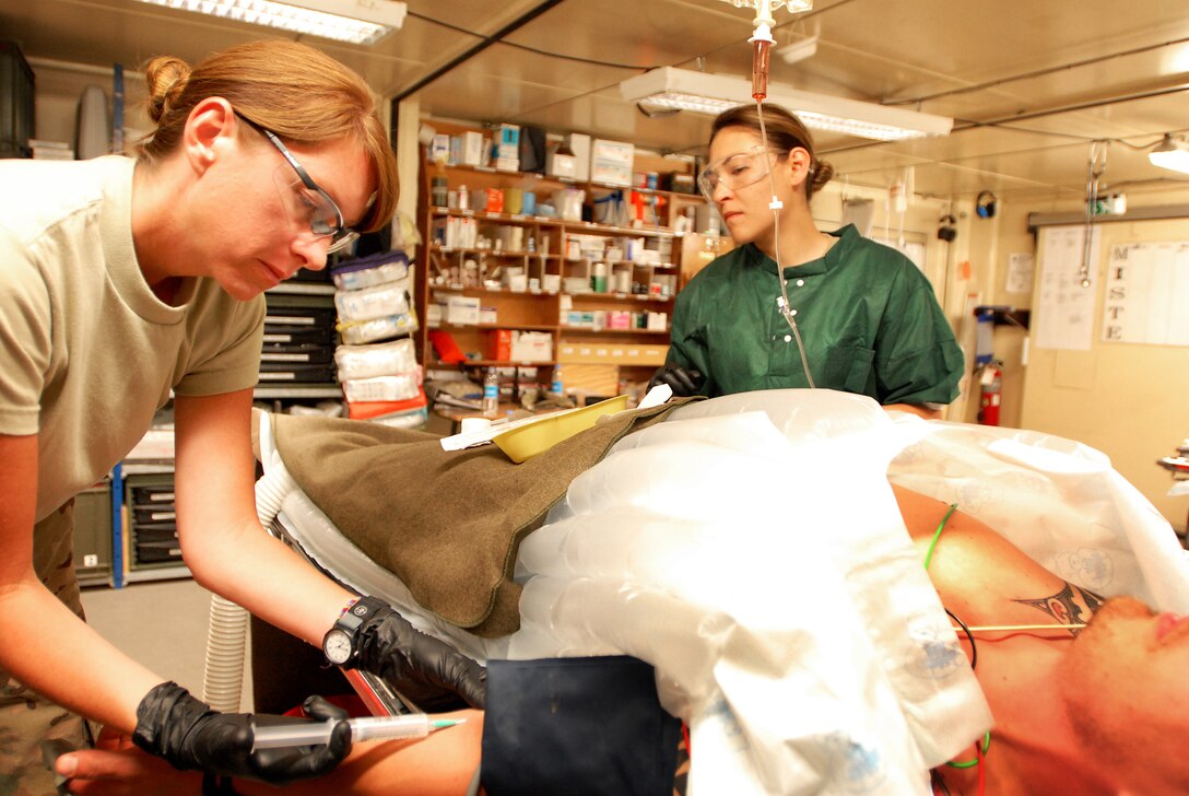 U. S. Navy Lt. Betsy Hoyos De Albers starts an intravenous line in the ...