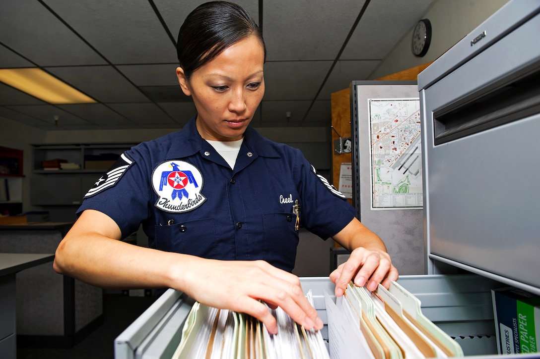 Air Force Master Sgt. Gina Creel sorts through squadron personnel files ...
