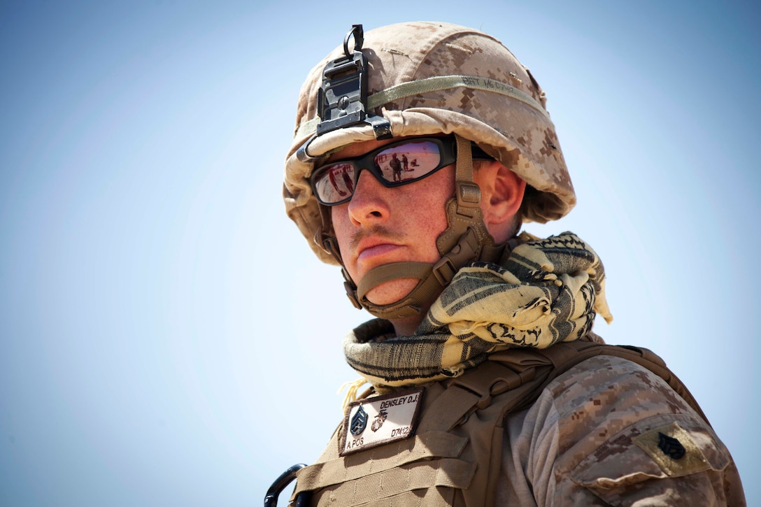 U.S. Marine Corps Staff Sgt. David Denseley watches as an Afghan ...