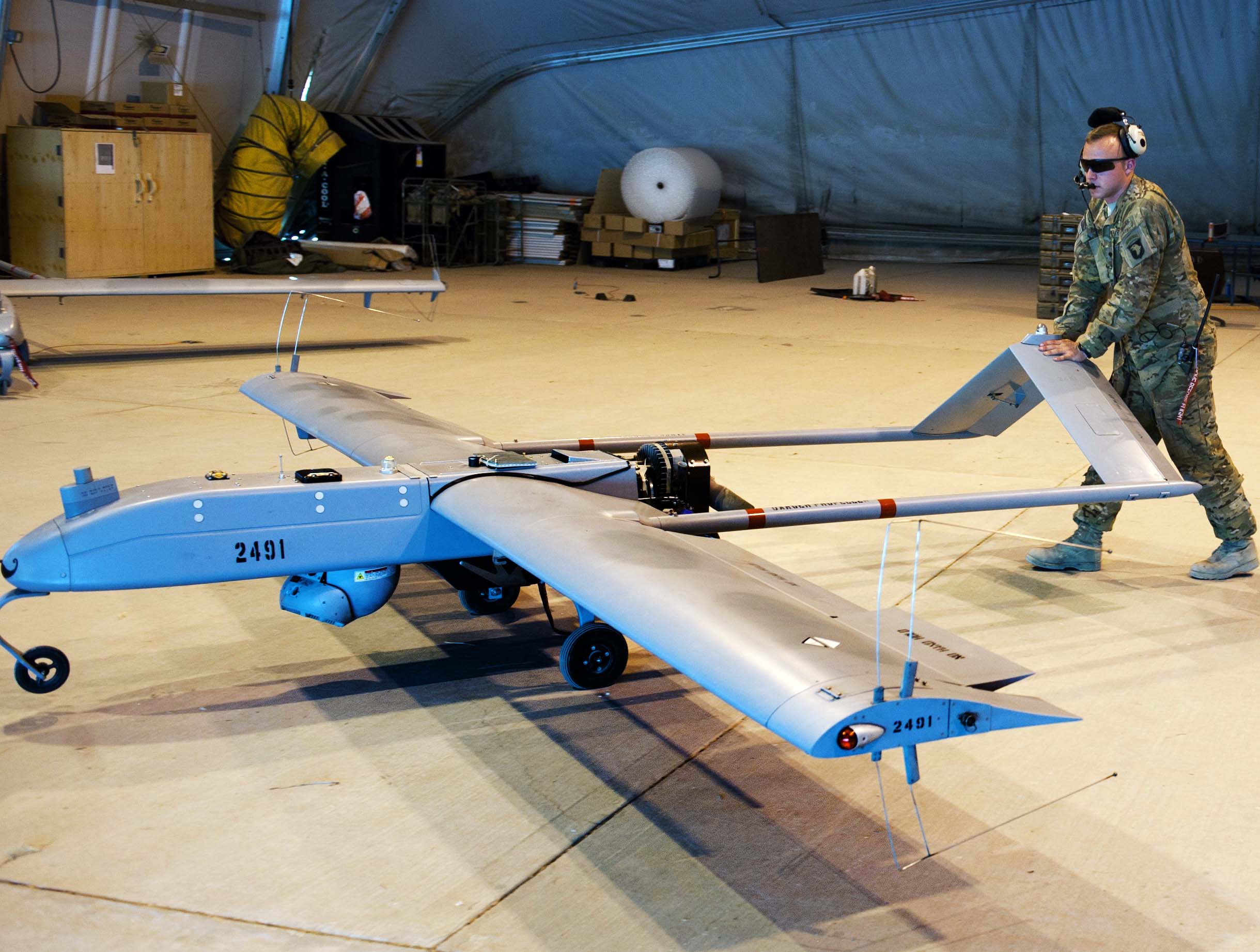 U.S. Army Spc. Tyler Brewer pushes an RQ-7B Shadow out of the hangar at ...