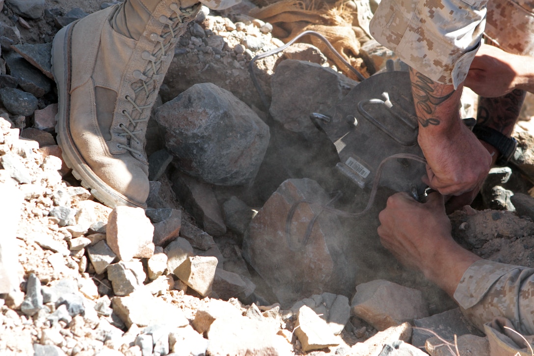 Marines conceal a simulated improvised explosive device using rocks and ...