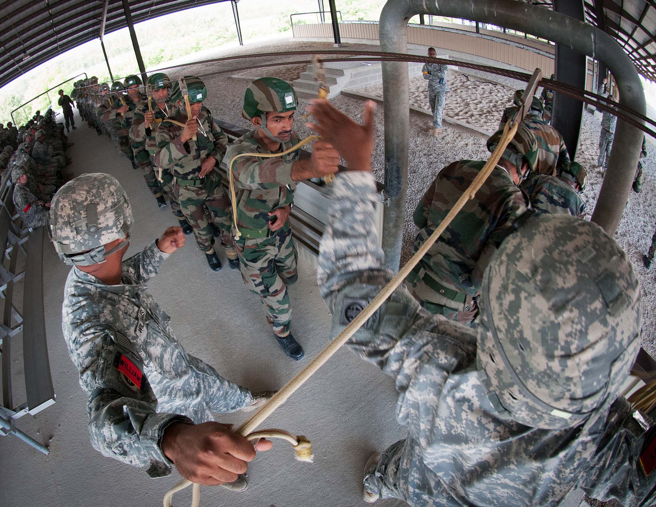 An Indian army paratrooper hands his static line to a U.S. Army ...