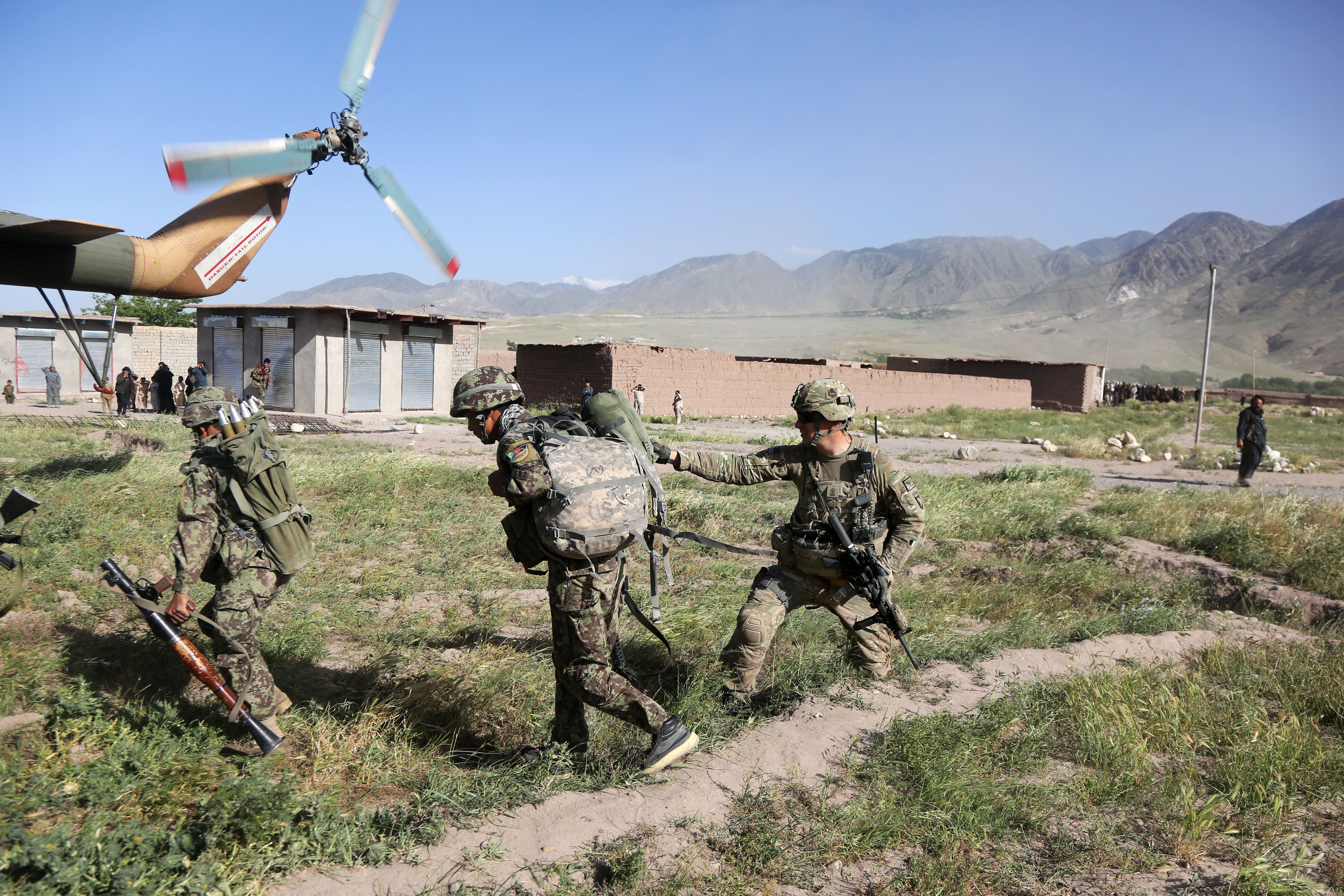 A U.S. soldier directs Afghan soldiers loading into the back of a ...