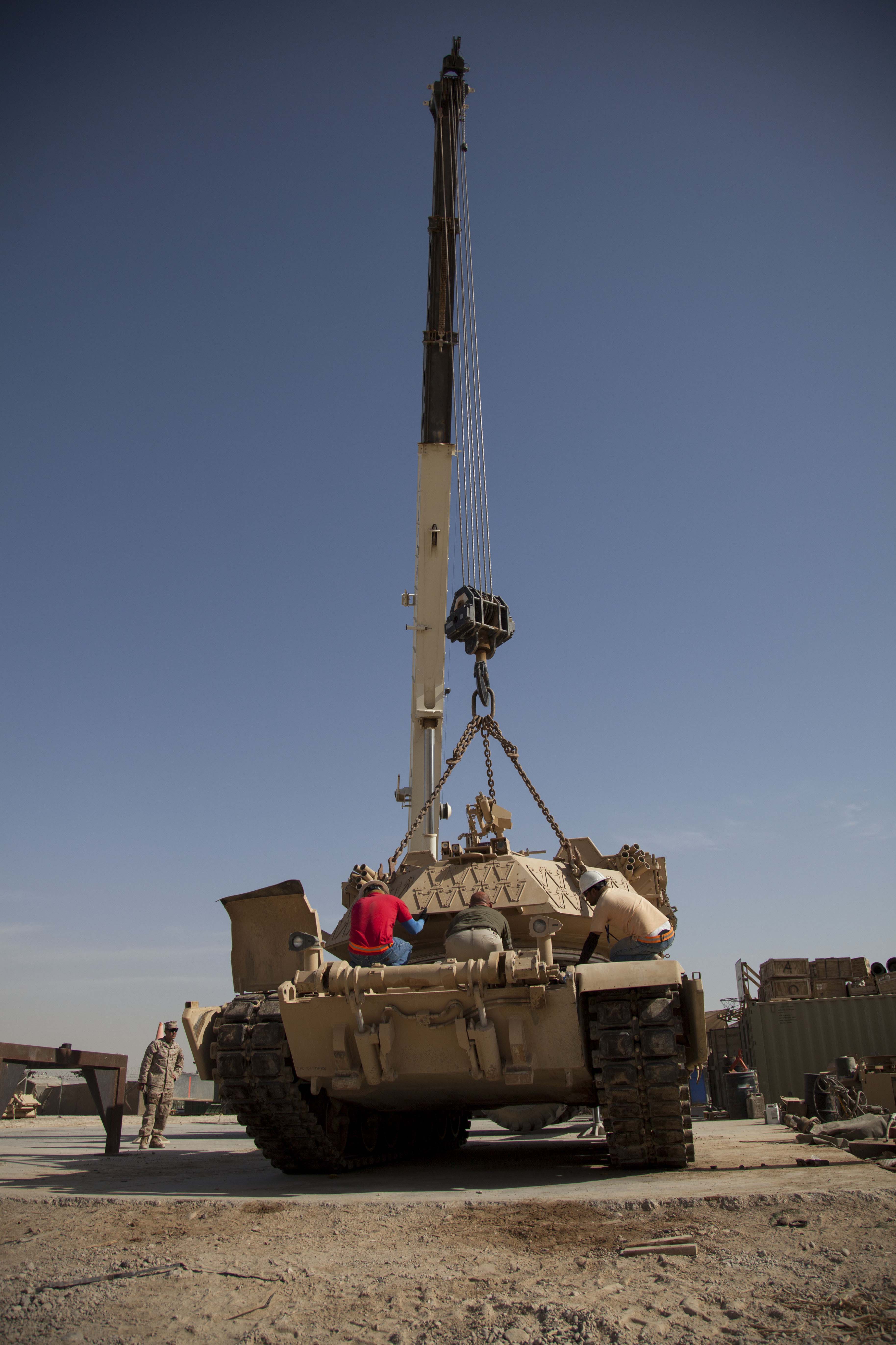 U.S. Marines and Defense Department civilians place a turret on an M1 ...