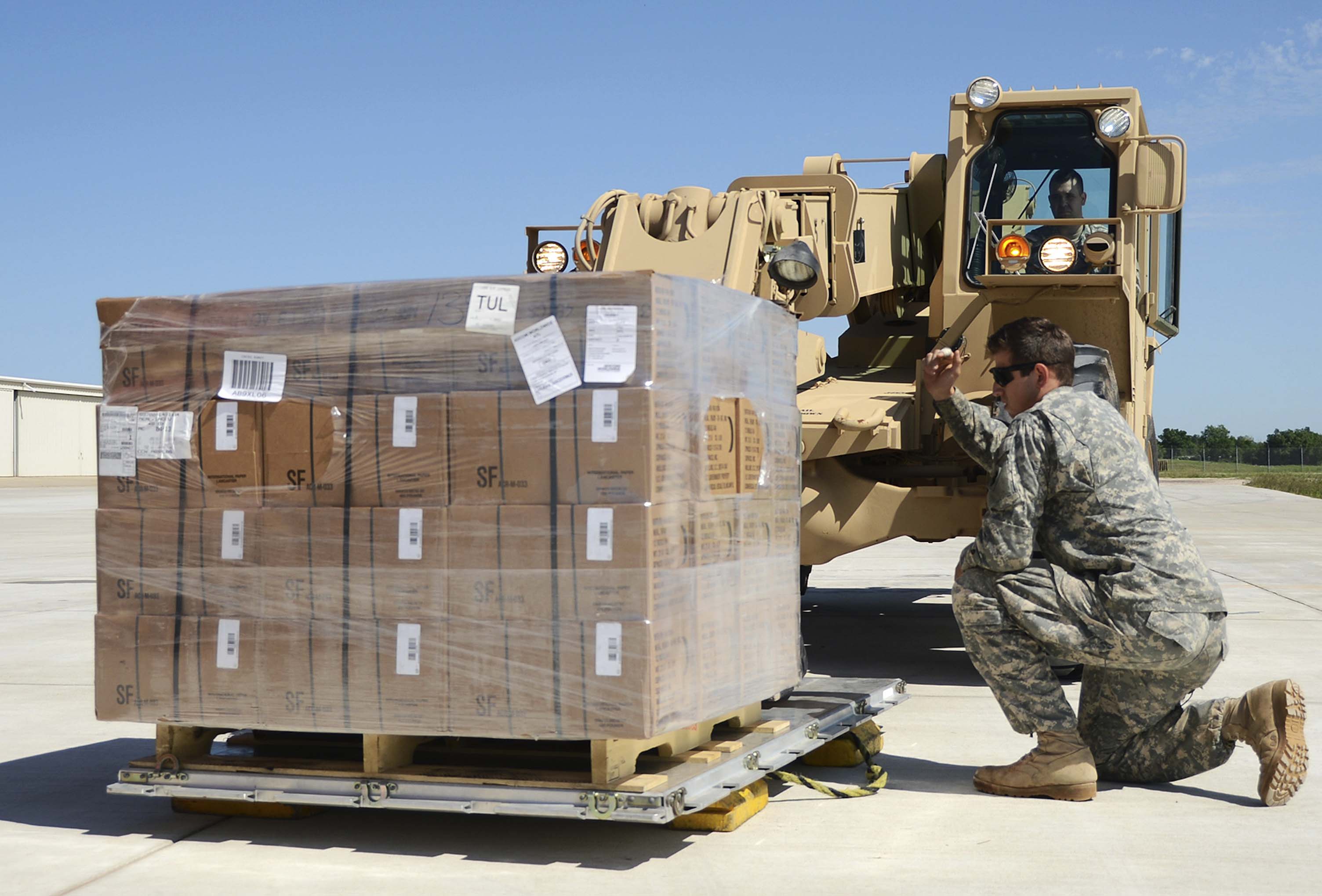 Army Spc. Travis Wells uses hand signals to direct Army Sgt. Matthew ...