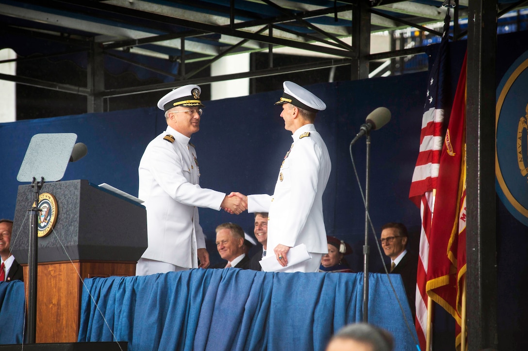Commandant of Midshipmen Capt. Robert E. Clark II shakes hands with ...