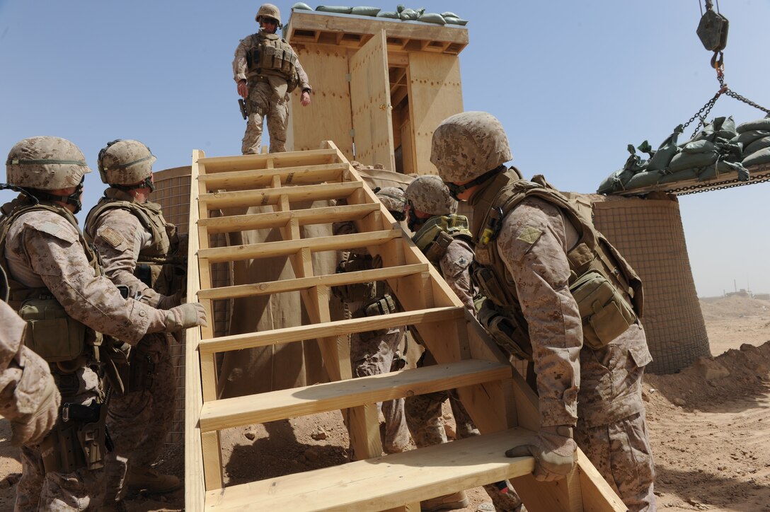U.S. Seabees move a stairwell in place as they construct a bunker in ...