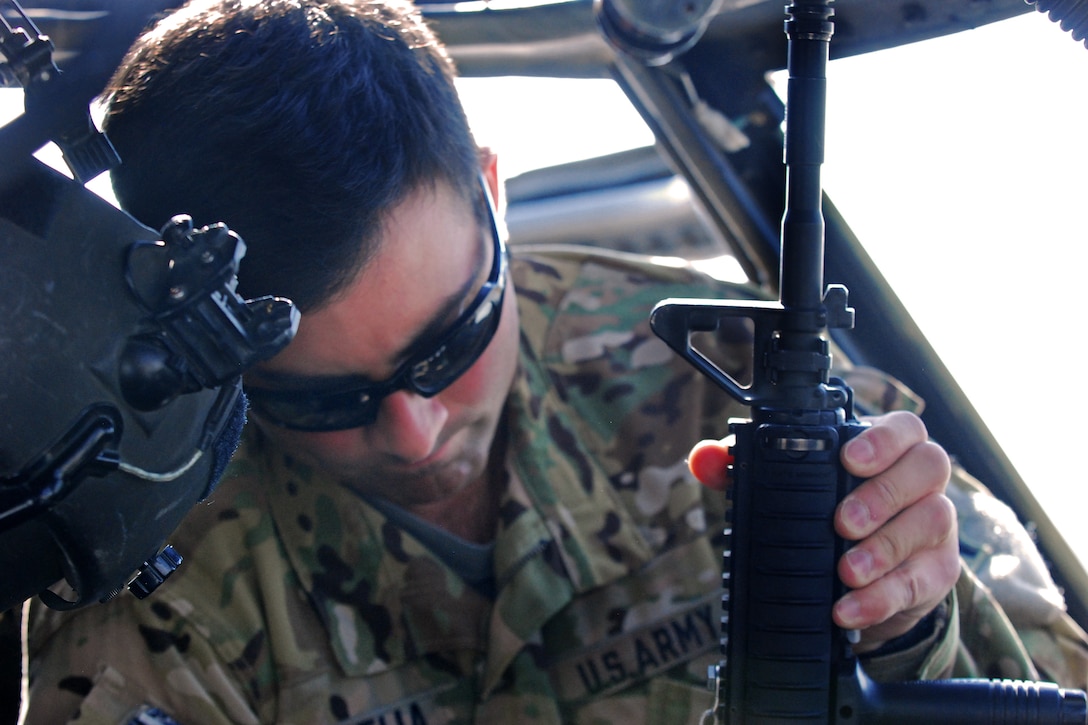U.S. Army Chief Warrant Officer 2 Tony Celia stows his M-4 assault ...