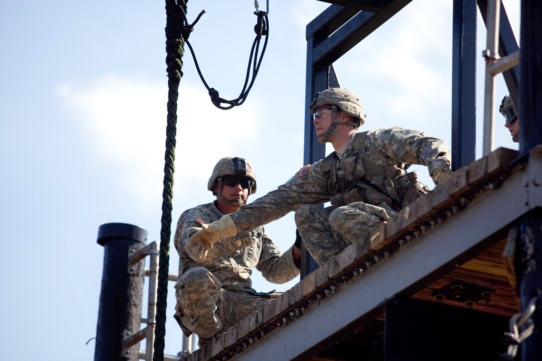 Army Staff Sgt. Ronnie Talsma, left, directs Army Sgt. Matthew Macario ...