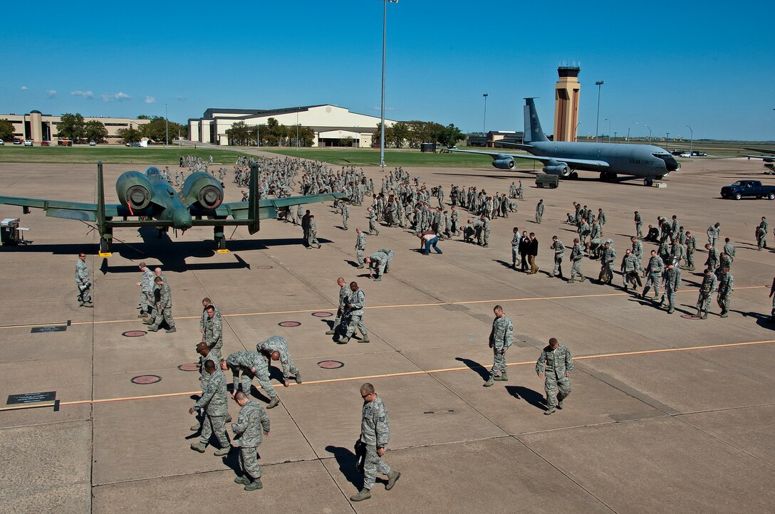 Airman and civilian employees, perform a Foreign Object Damage (FOD) Walk