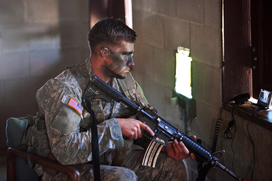 A soldier watches a monitor attached to a camera system used in urban ...