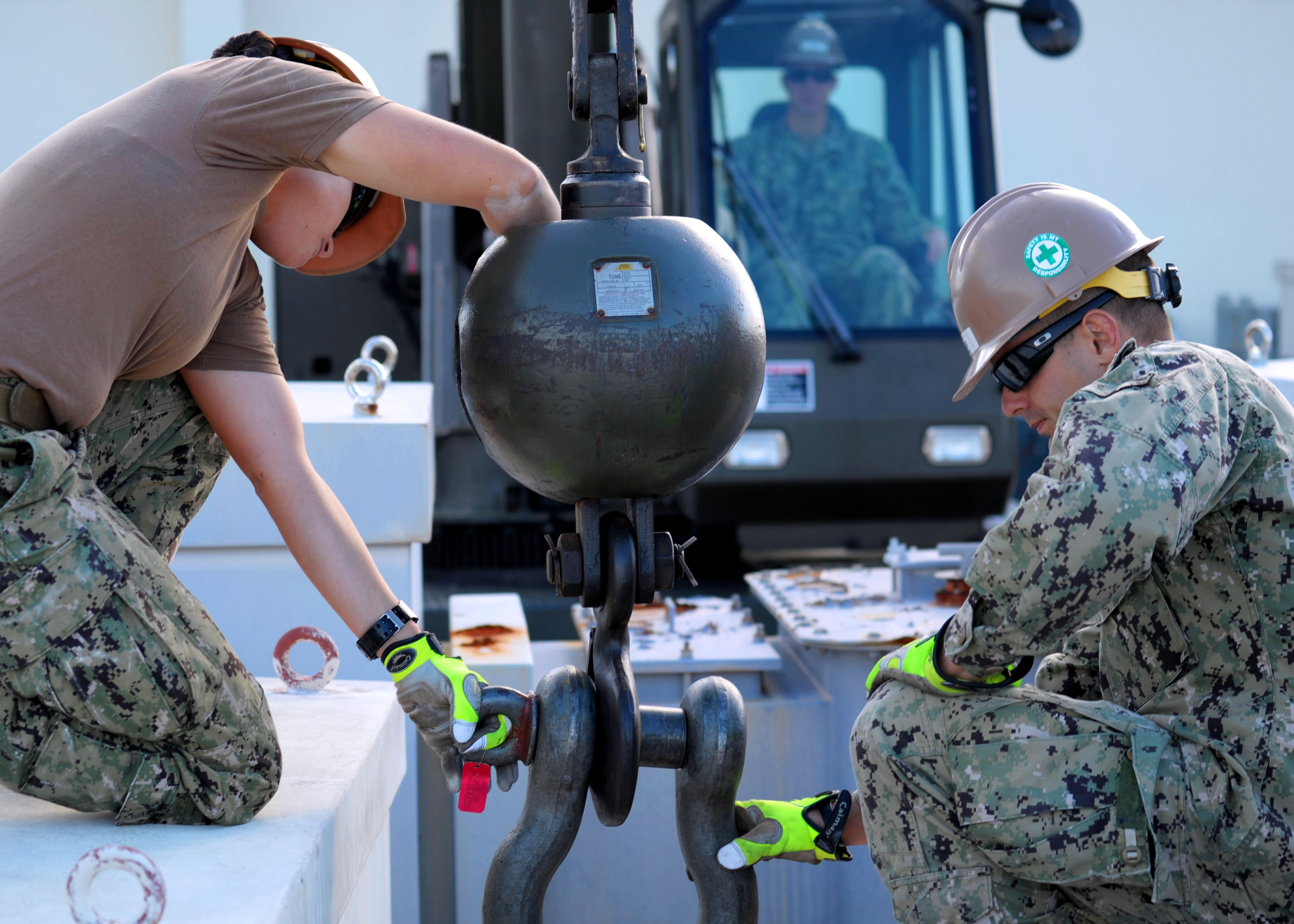 U.S. Navy Seabees lock down the rigging shoe of a 40-ton hydraulic ...