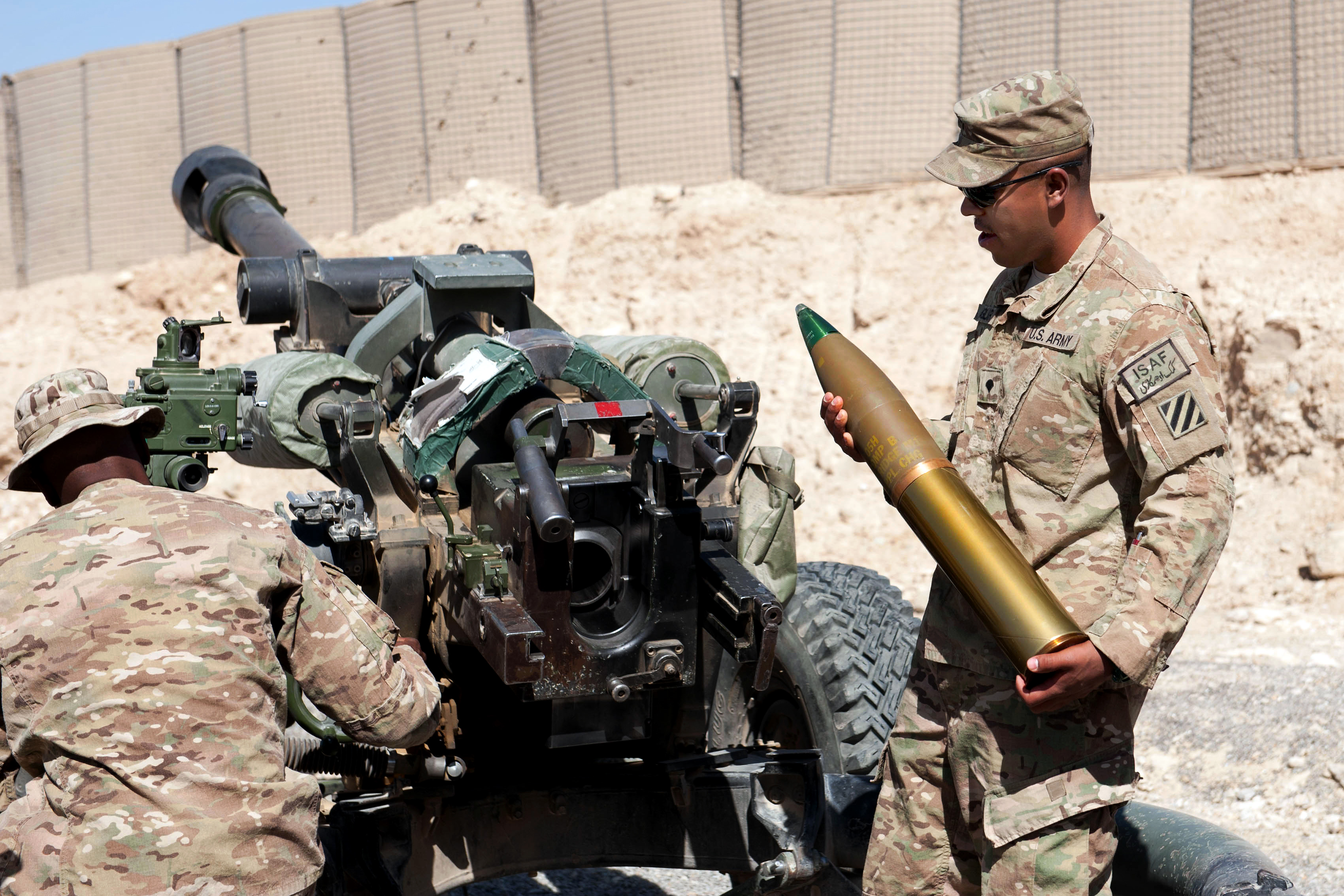 U.S. Army Spc. Victor Aguilar simulates loading a 105-mm M119A2 ...