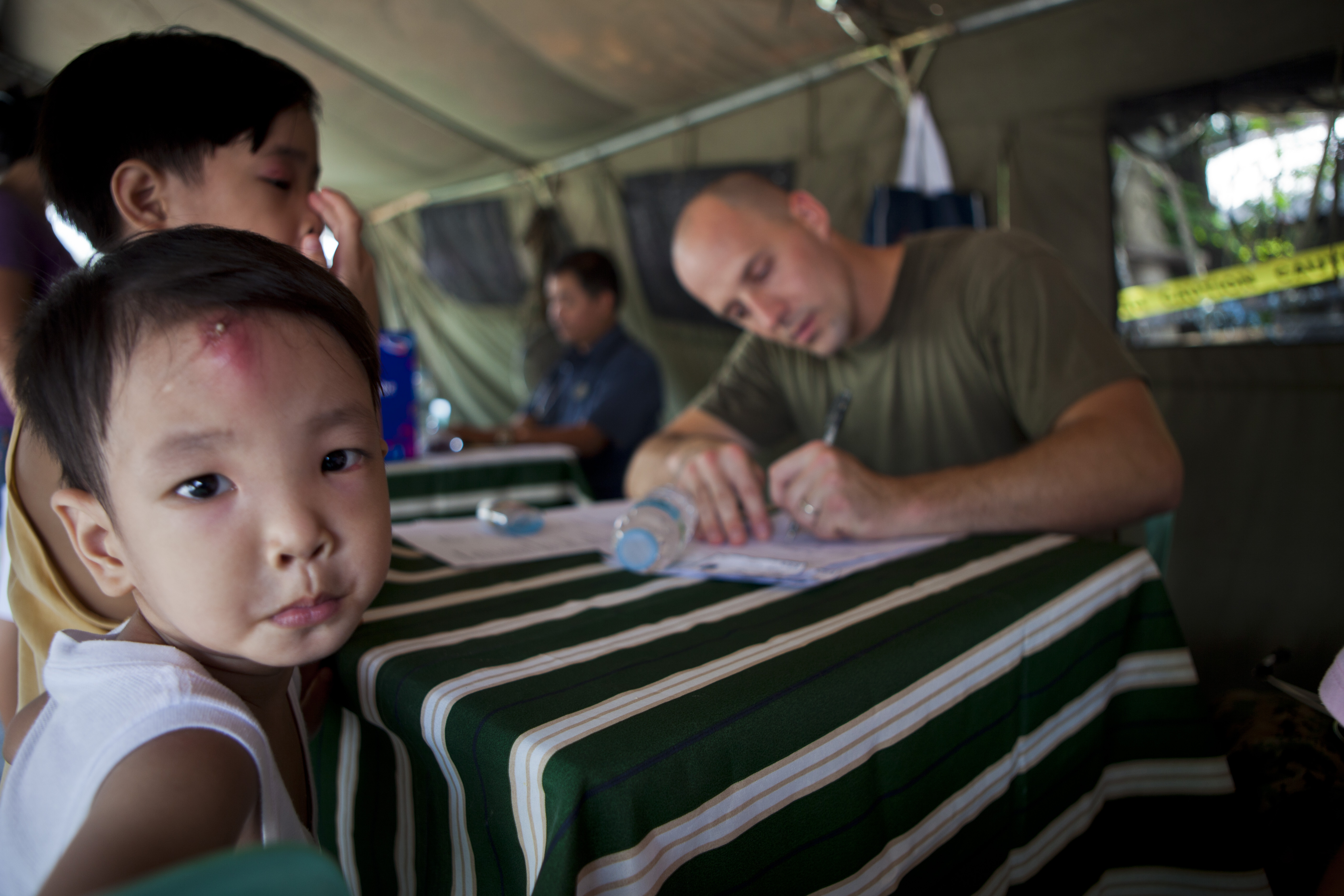A Filipino child waits to receive treatment from U.S. Navy Petty ...