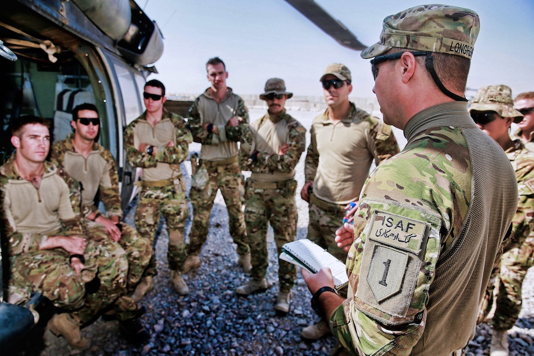 U.S. Army Staff Sgt. Michael A. Longhenry, foreground, explains the ...