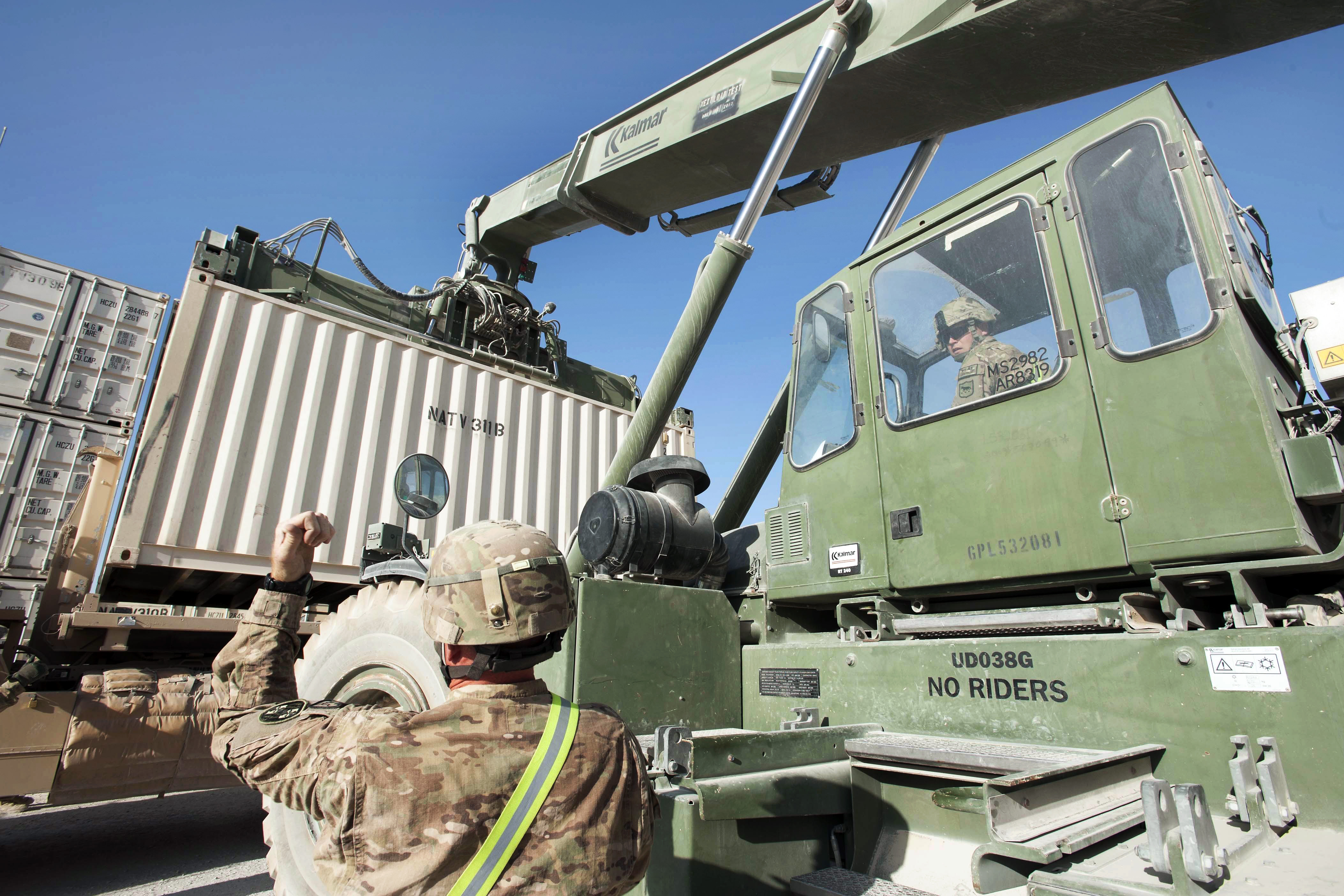 U.S. Army Staff Sgt. Adam Holen operates a rough terrain container ...