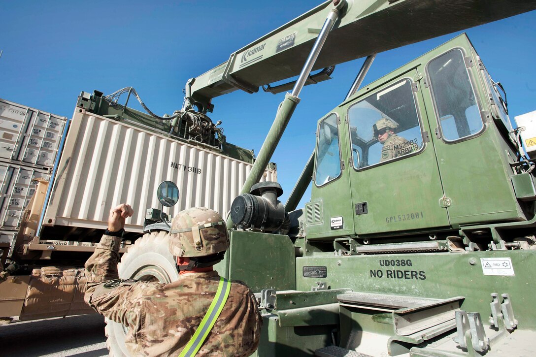 U.S. Army Staff Sgt. Adam Holen operates a rough terrain container ...