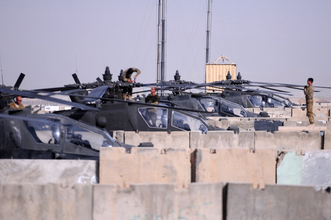 U.S. soldiers perform maintenance on AH-64 Apache helicopters while on ...